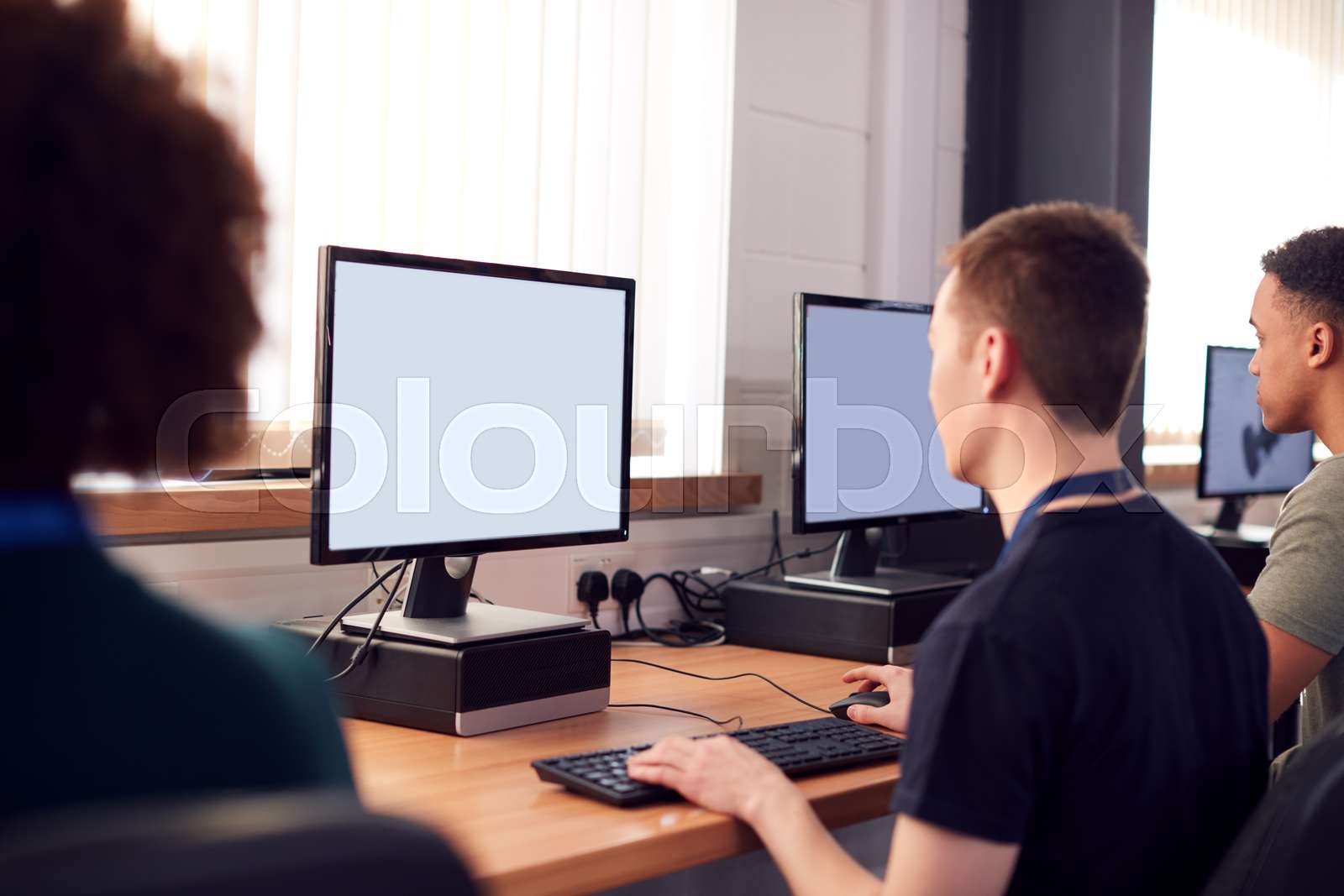 Group Of College Students Studying Computer Design Sitting At Line Of ...