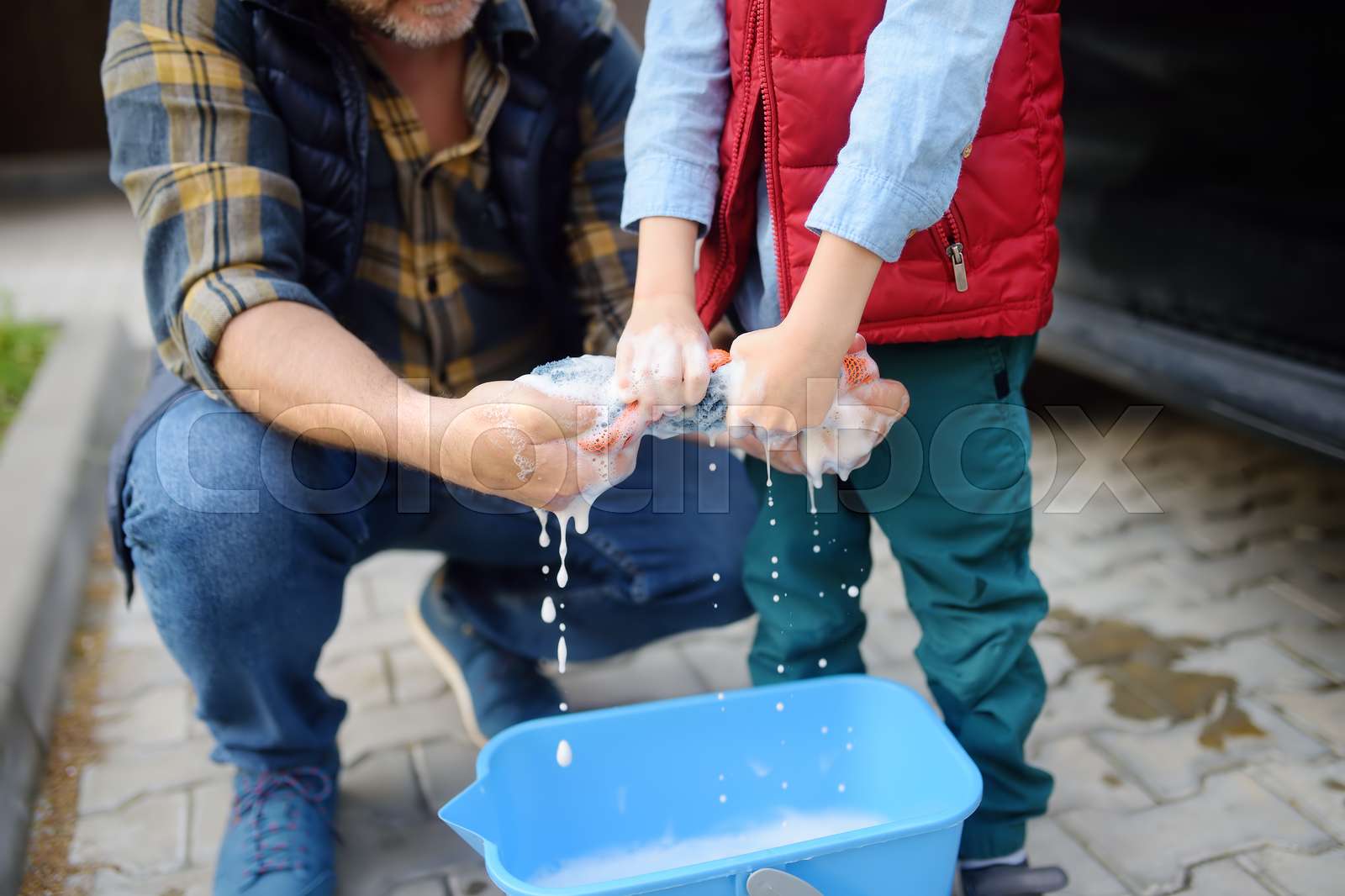 Preschooler boy helping his father washing family car. Little dad ...