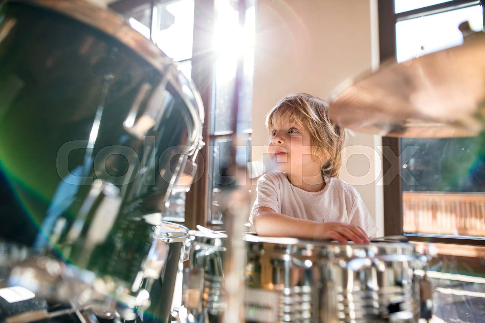 Portrait of small boy indoors at home, playing drums. | Stock image ...