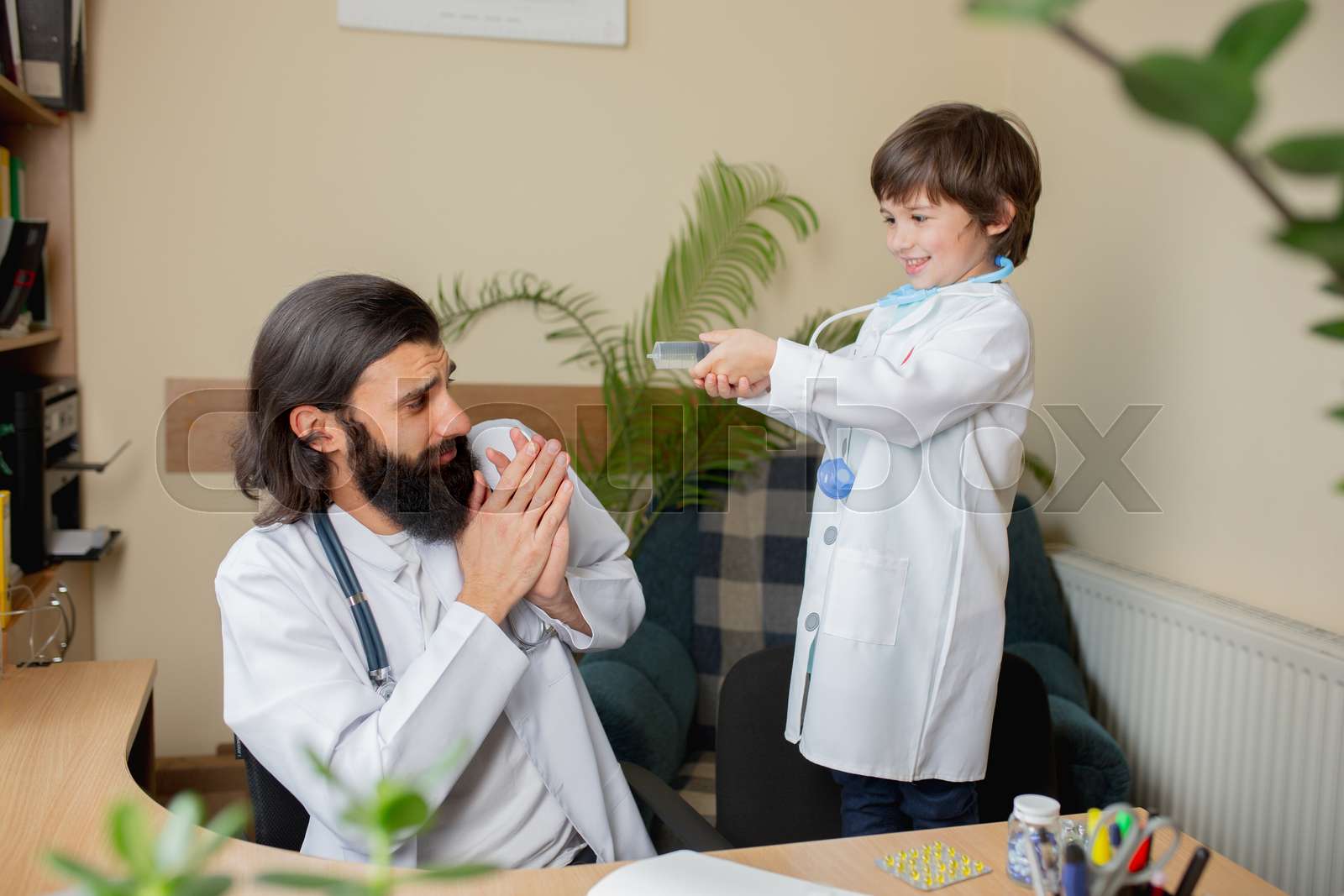 Paediatrician doctor examining a child in comfortabe medical office ...