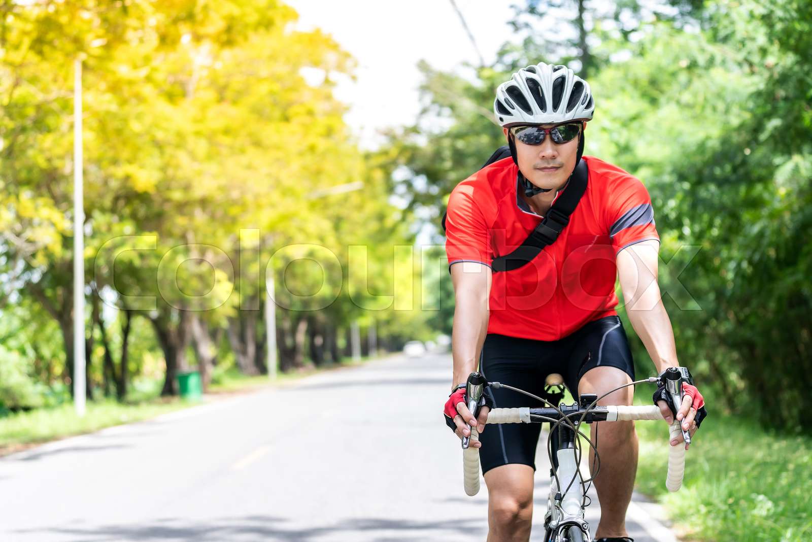 Asian man cycle in countryside road | Stock image | Colourbox