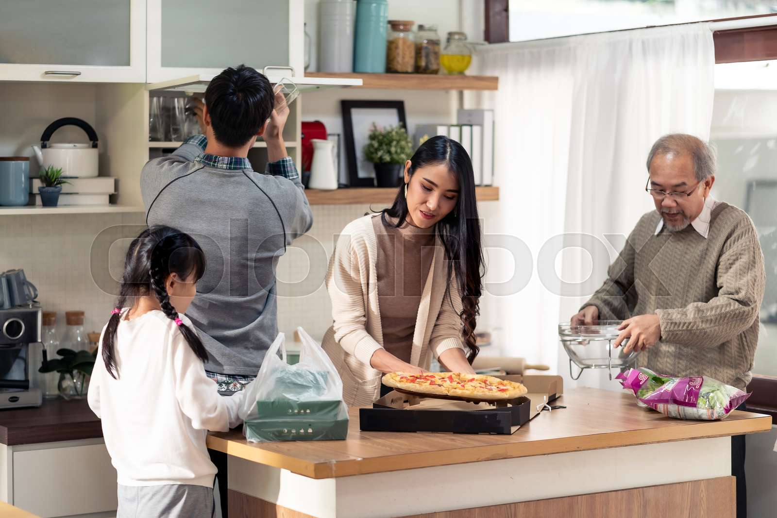 multigenerational family setting up dining table tagether | Stock image ...