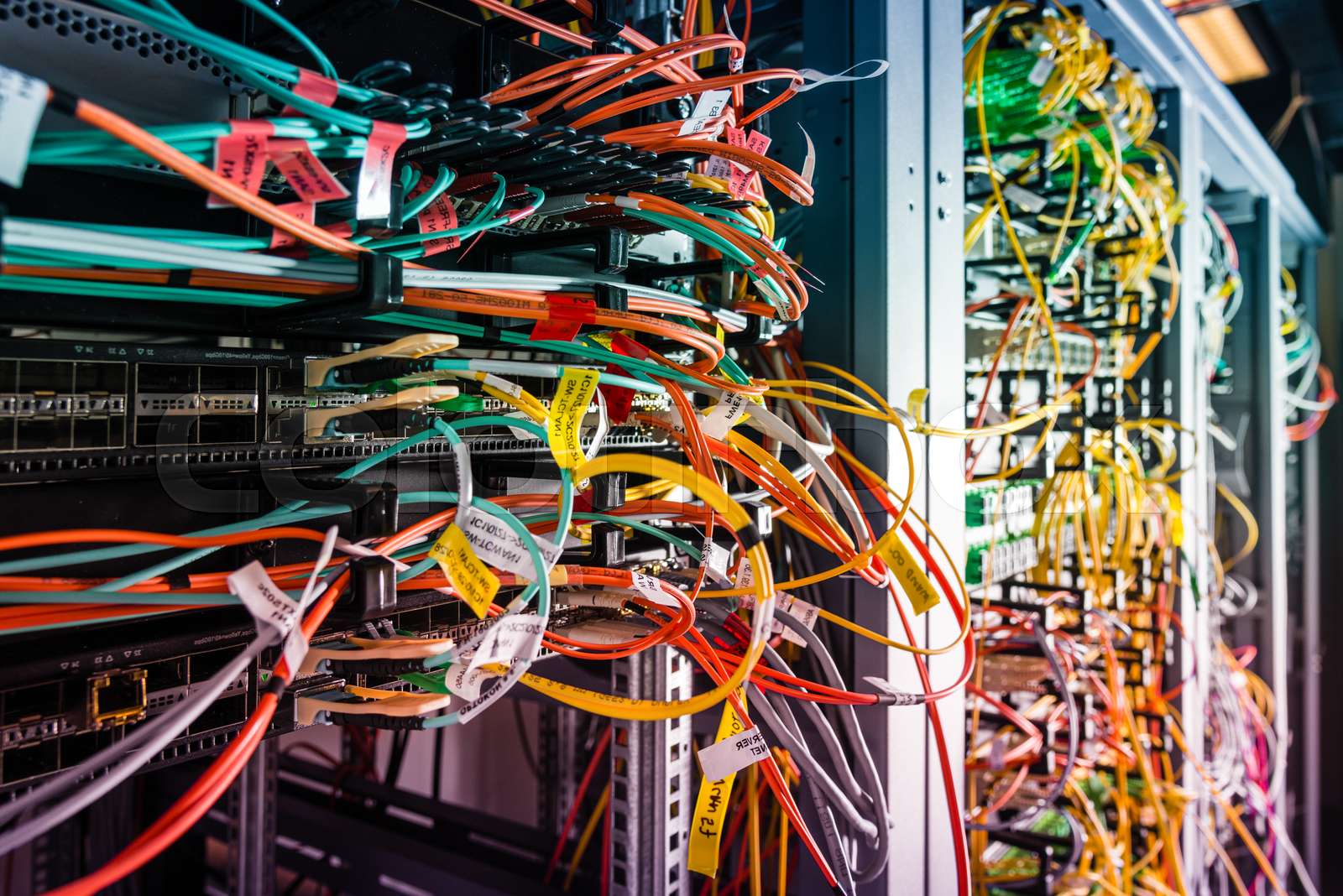 Server rack with fiber optic cables attached to front panel swit ...