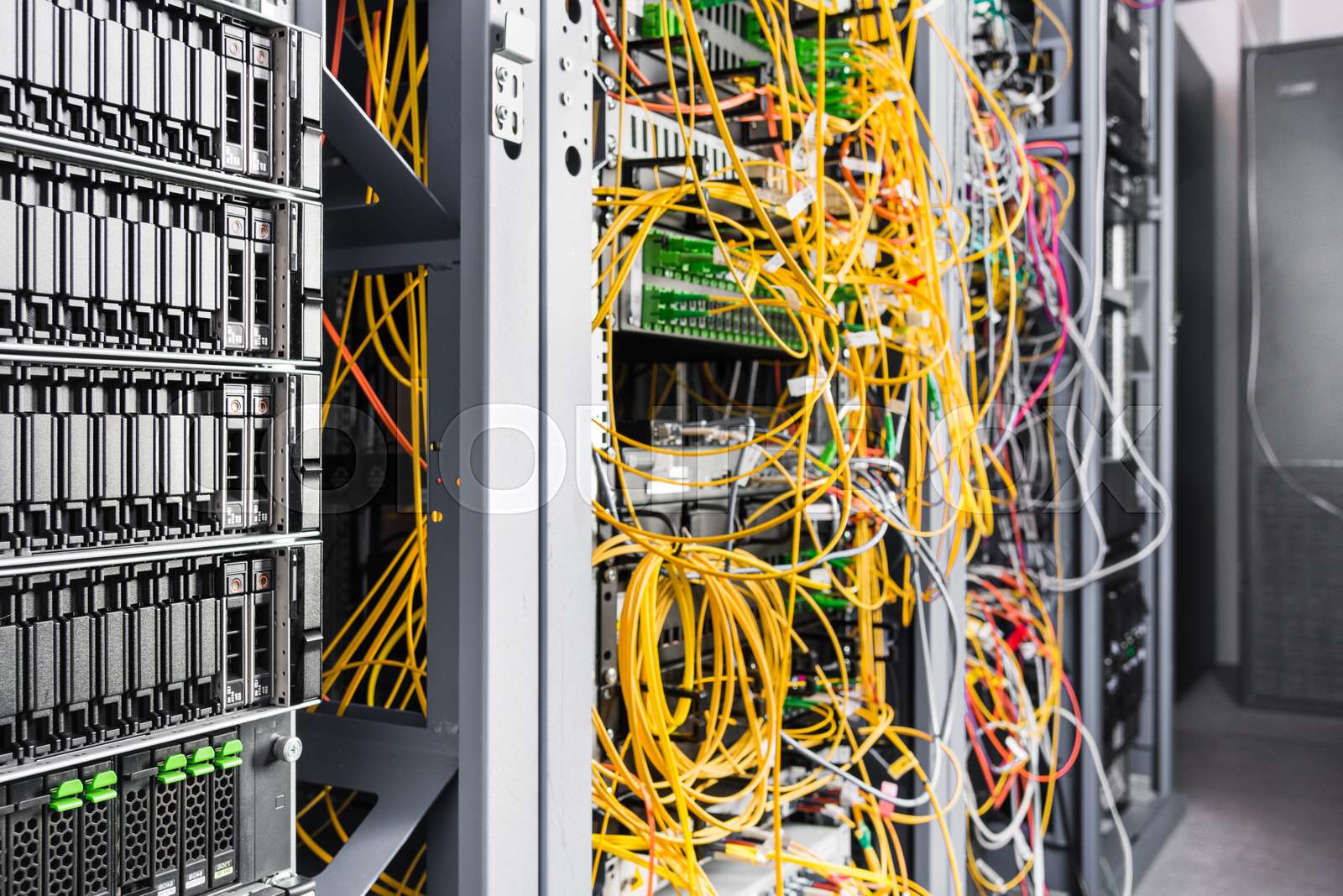 Server rack with fiber optic cables attached to front panel swit ...