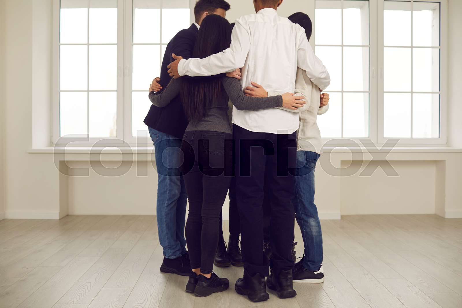 Young people embracing each other in corporate work meeting or in group ...