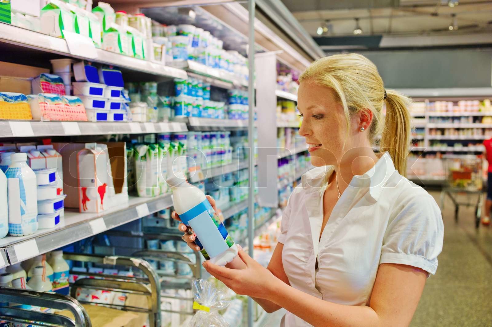 woman buying milk at the grocery store | Stock image | Colourbox