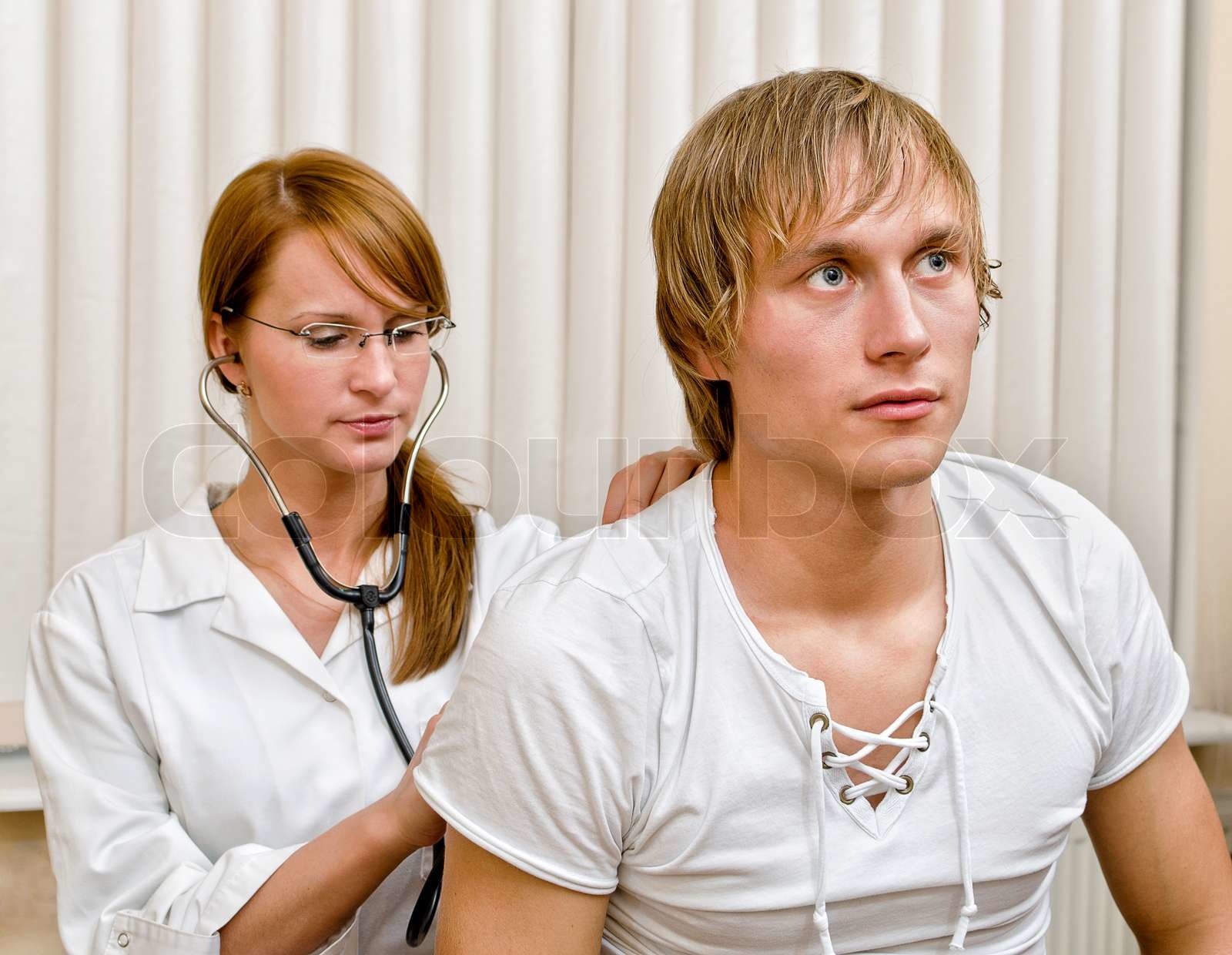 Young Female Doctor Examine Male Patient With Stethoscope Stock Image