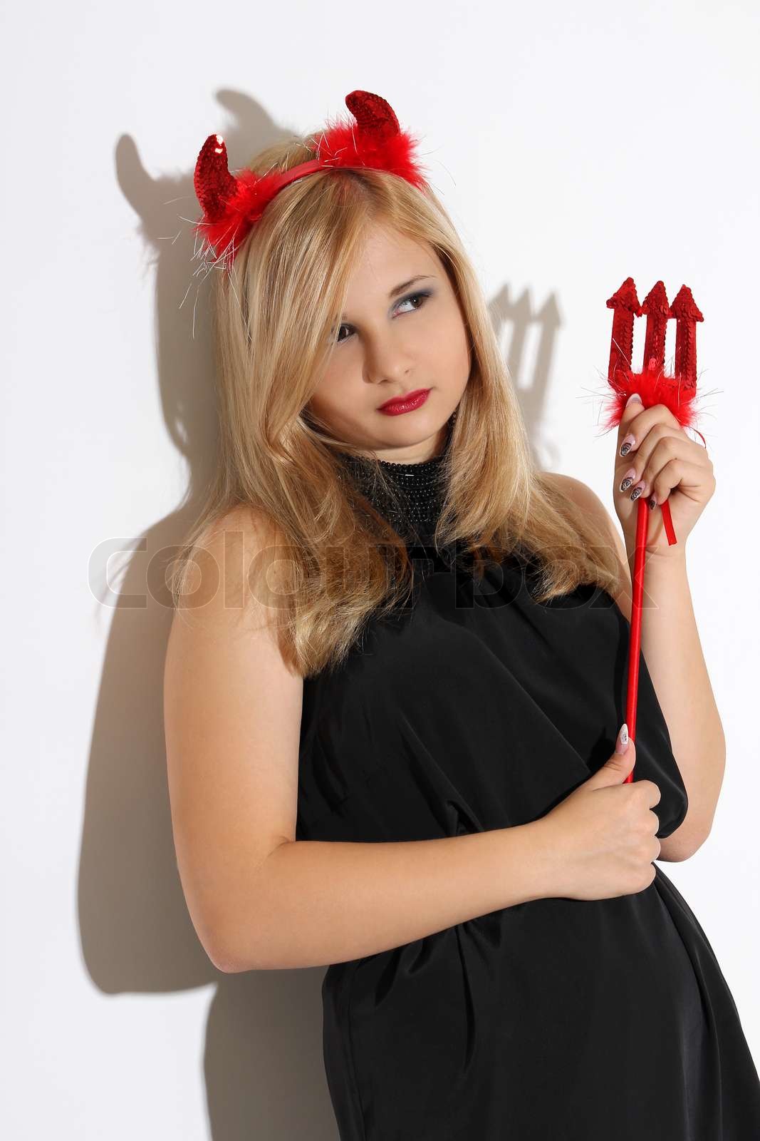 Blonde girl wearing a costume of an imp | Stock image | Colourbox