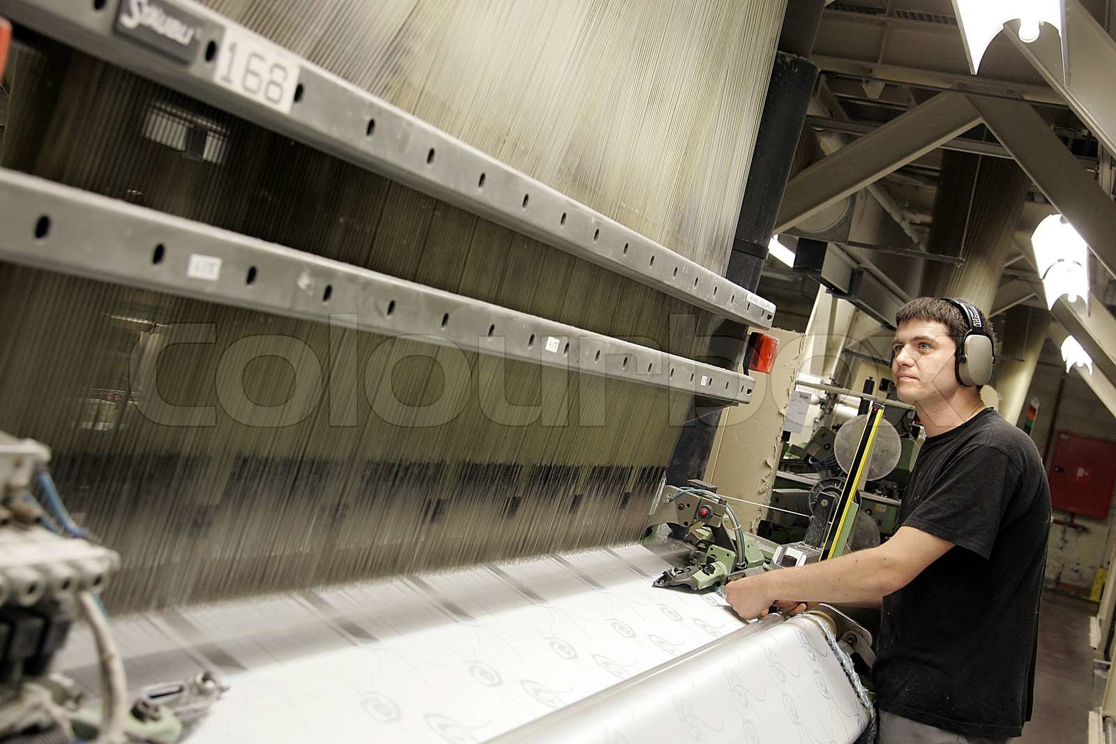 man operating an industrial loom | Stock image | Colourbox