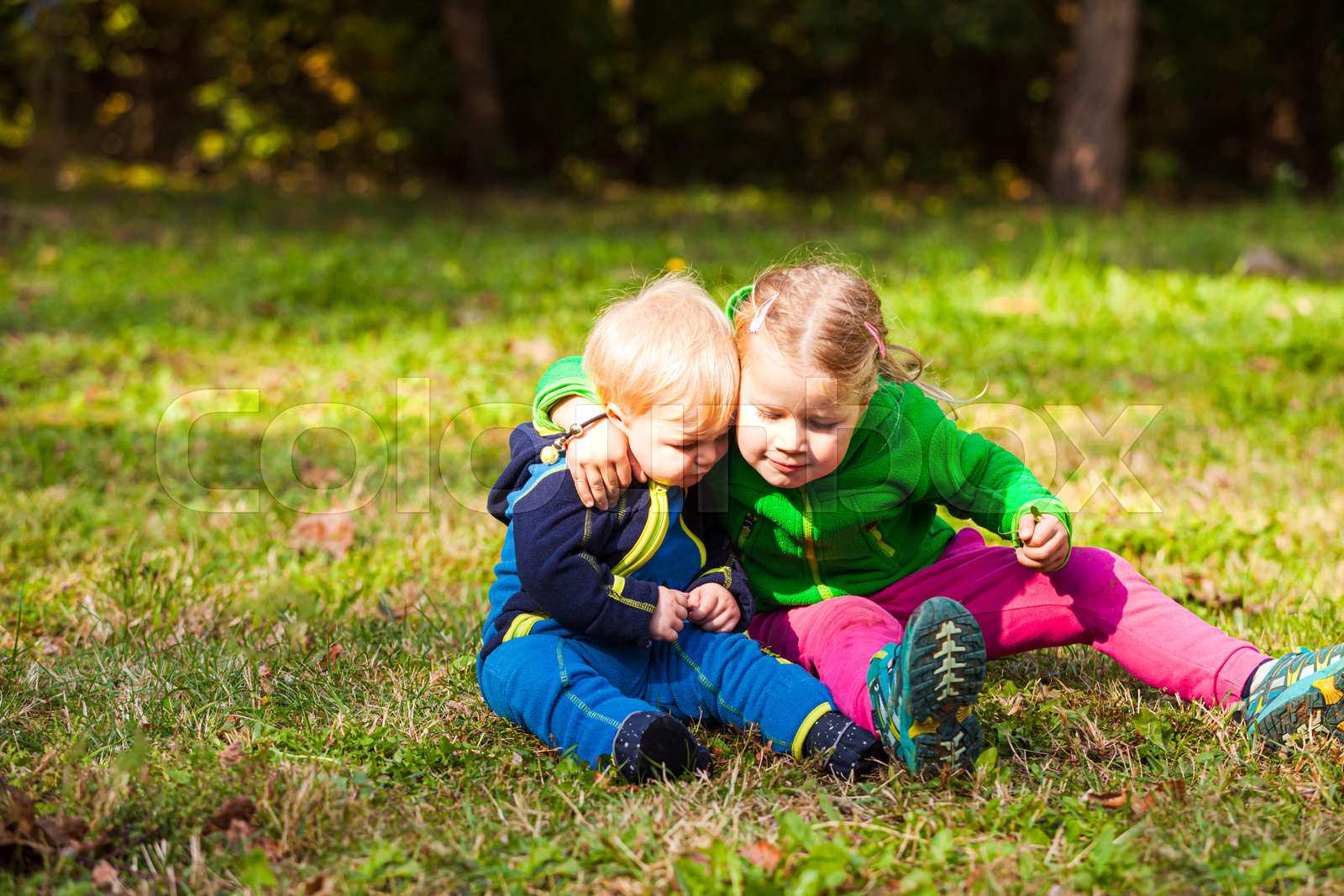 The cheerful girl is hugging her crying brother outdoor | Stock image ...