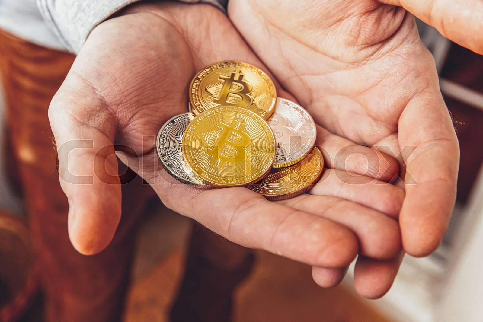 Man hand holding cryptocurrency golden and silver bitcoin coin ...