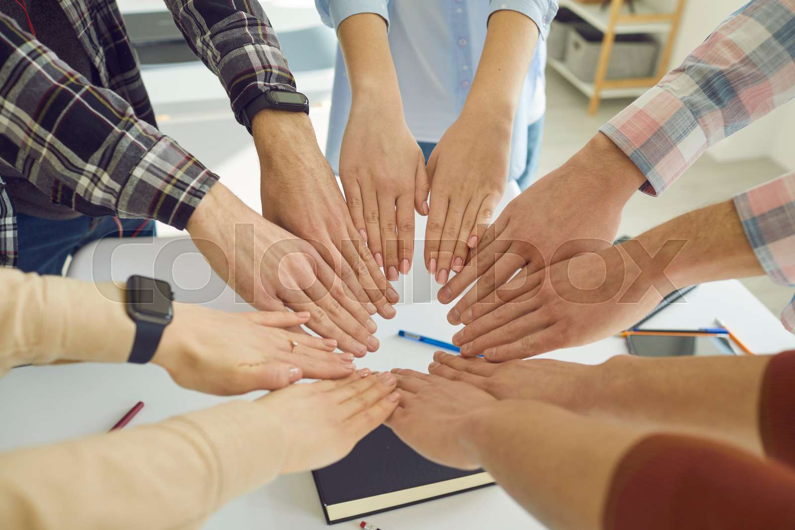 Group of school or college students join hands showing their unity and ...