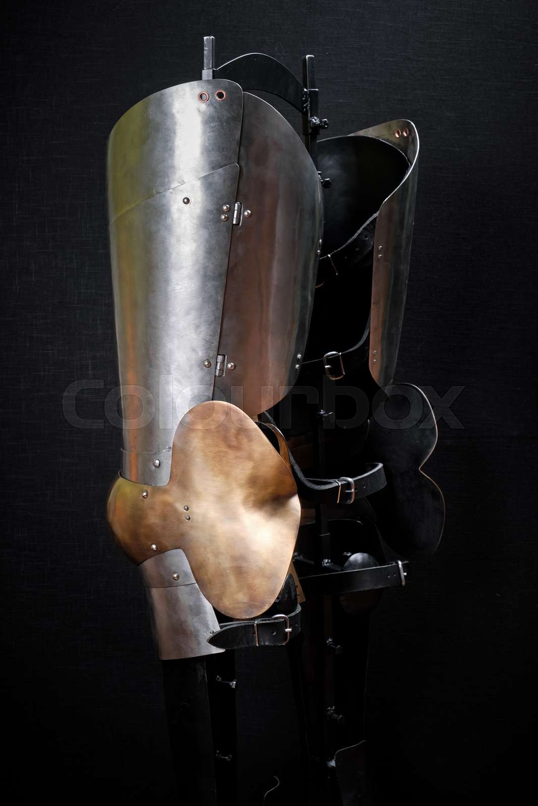 Knight armor for thigh and knees on a black | Stock image | Colourbox