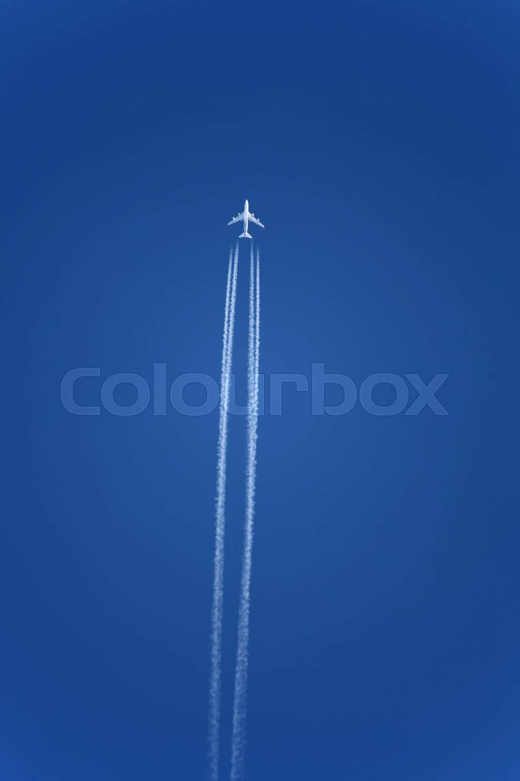 Jet stream from airplane travelling over clear blue sky | Stock image ...