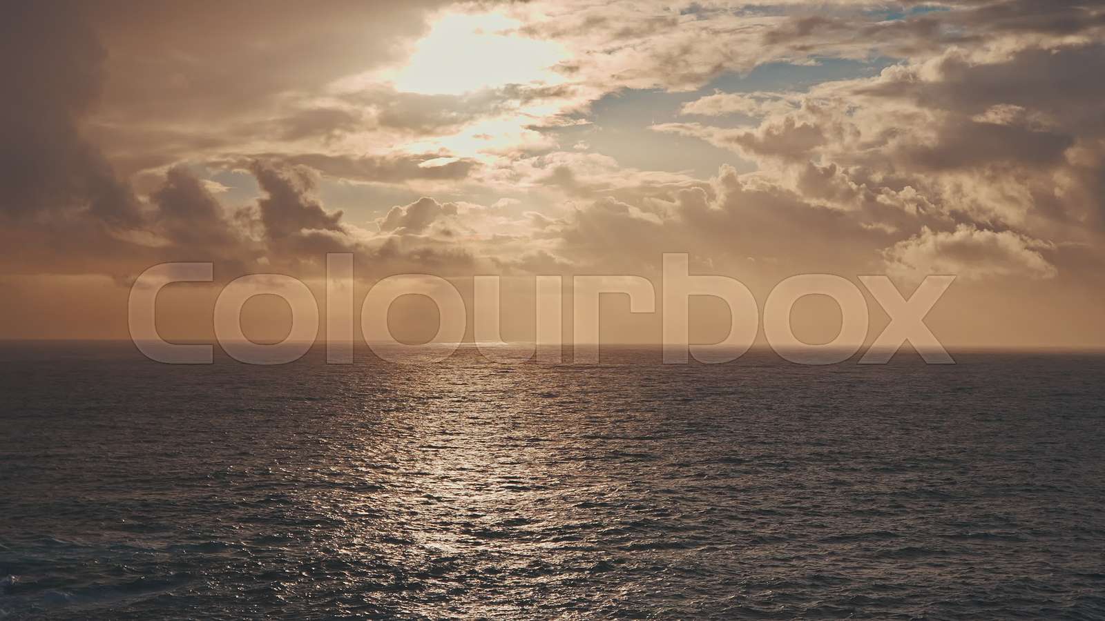 Dramatic sunrise over the ocean. A ray of the sun breaks through the ...