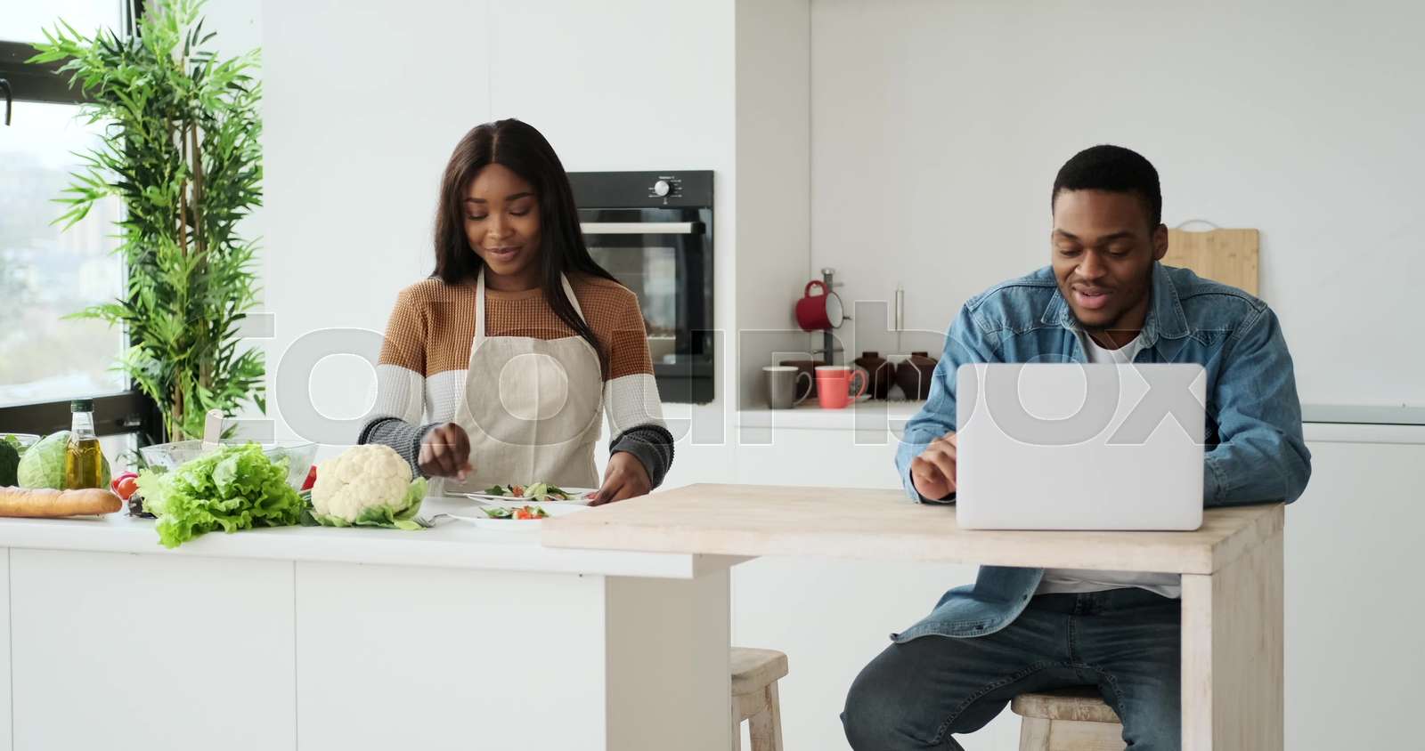 Businessman using laptop and having lunch with wife in kitchen | Stock ...