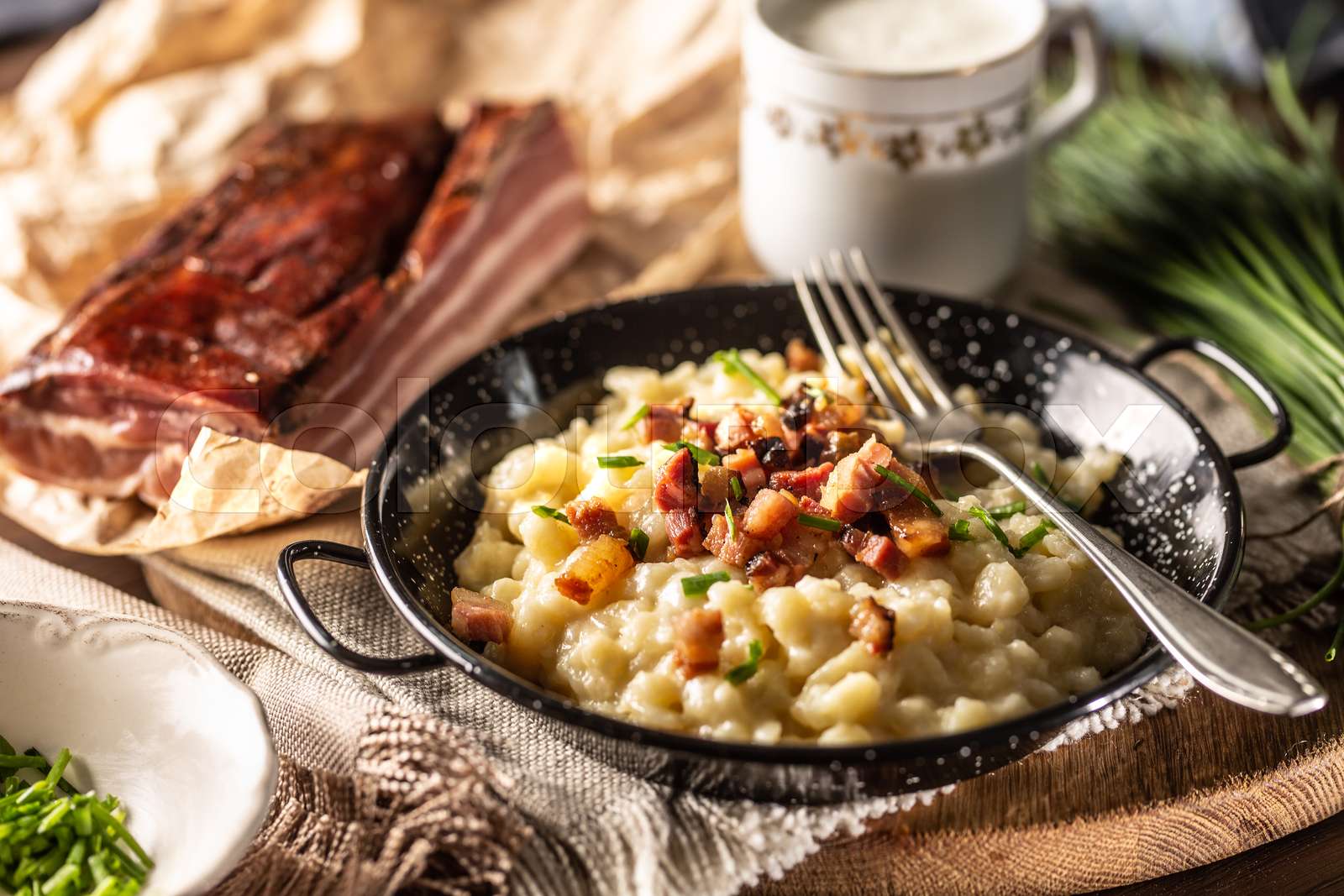 Slovak national dish bryndzove halushky served next to bacon and a gcup ...
