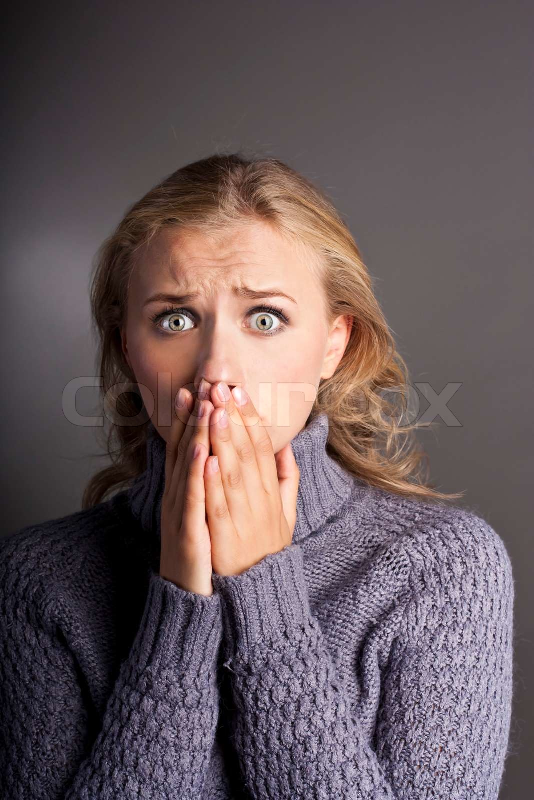 Frightened young woman in studio | Stock image | Colourbox