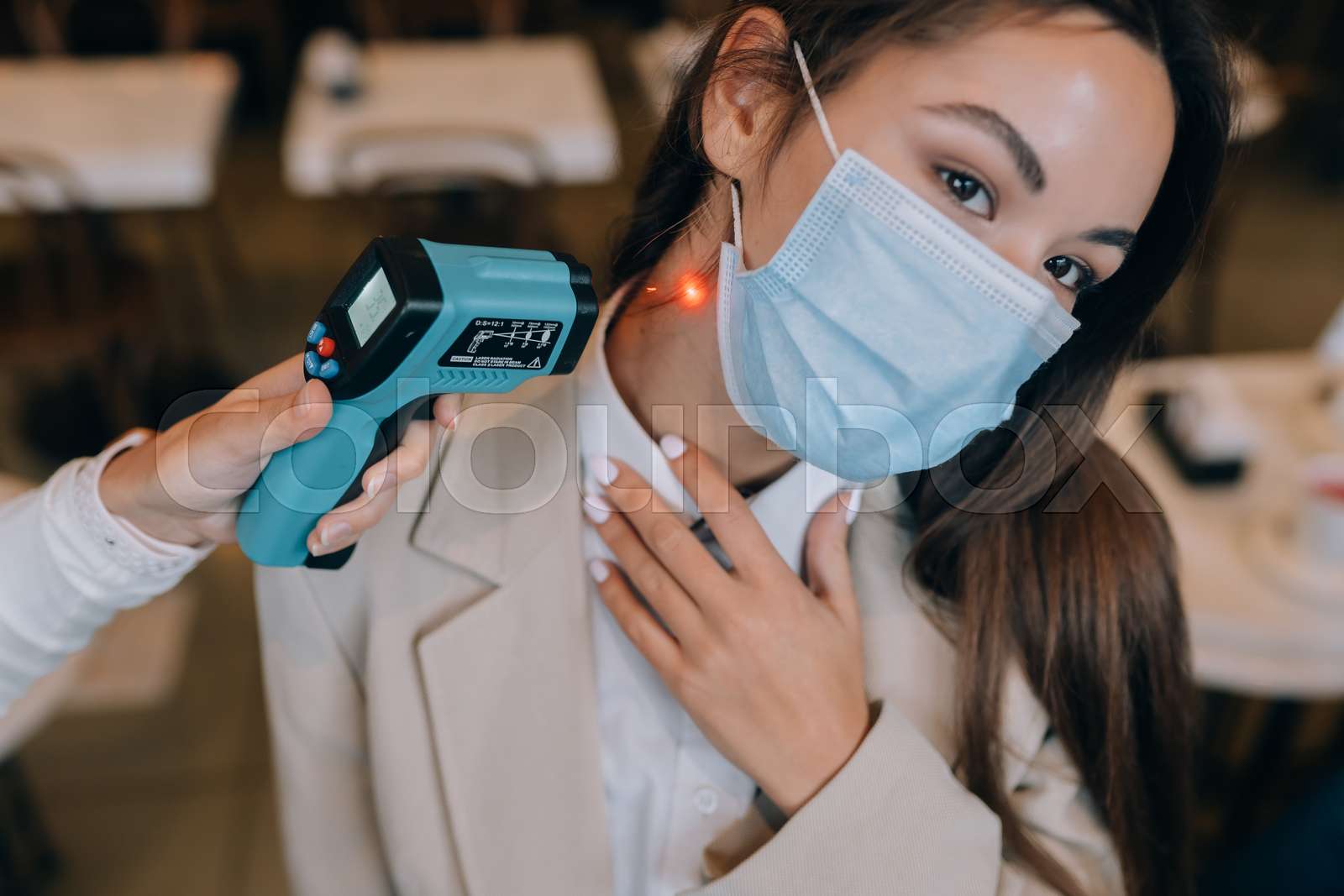 Measuring body temperature with contactless body thermometer | Stock ...