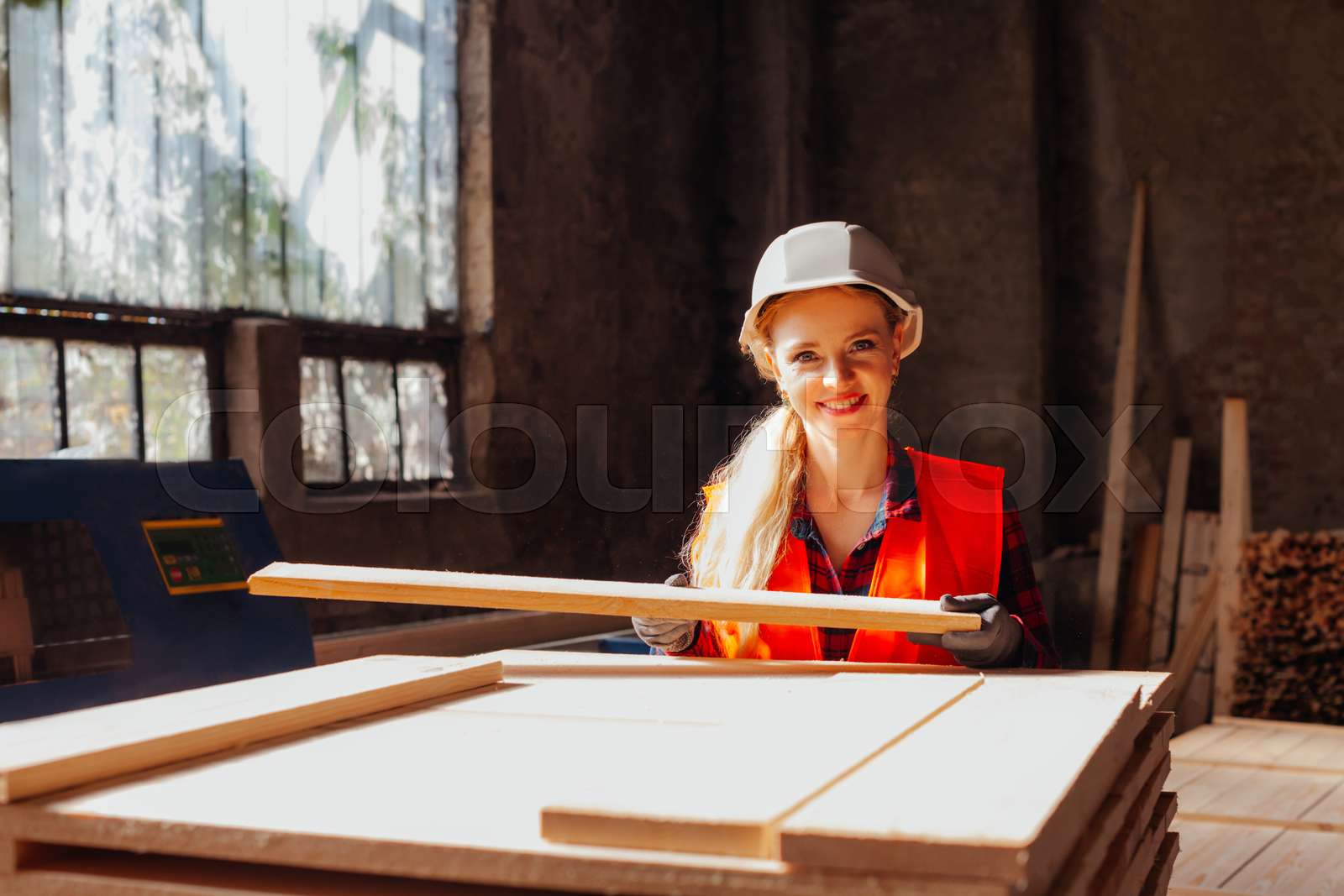 Attractive woman woodwork factory worker holding wooden plank | Stock ...