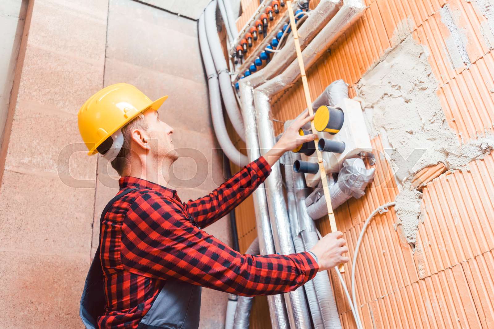 Male engineer installing the pipes | Stock image | Colourbox
