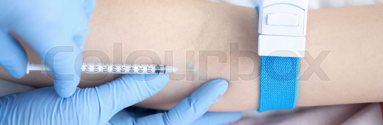 Nurse giving intravenous injection of medication to patient closeup ...