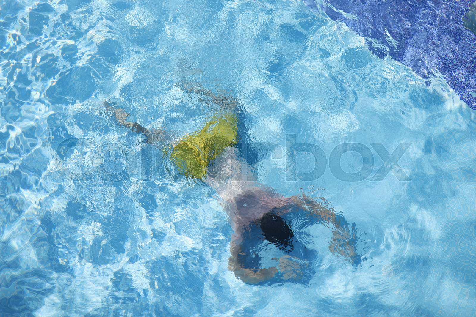 Young man lying on bottom of swimming pool top view | Stock image ...