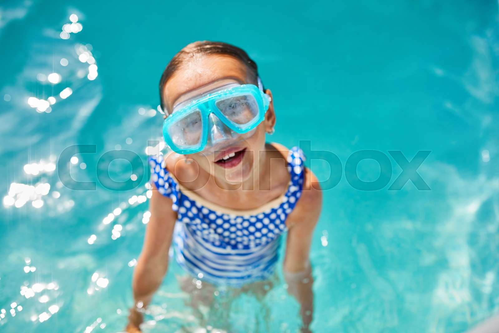 A child in goggles on the steps climbing out of the pool | Stock image ...