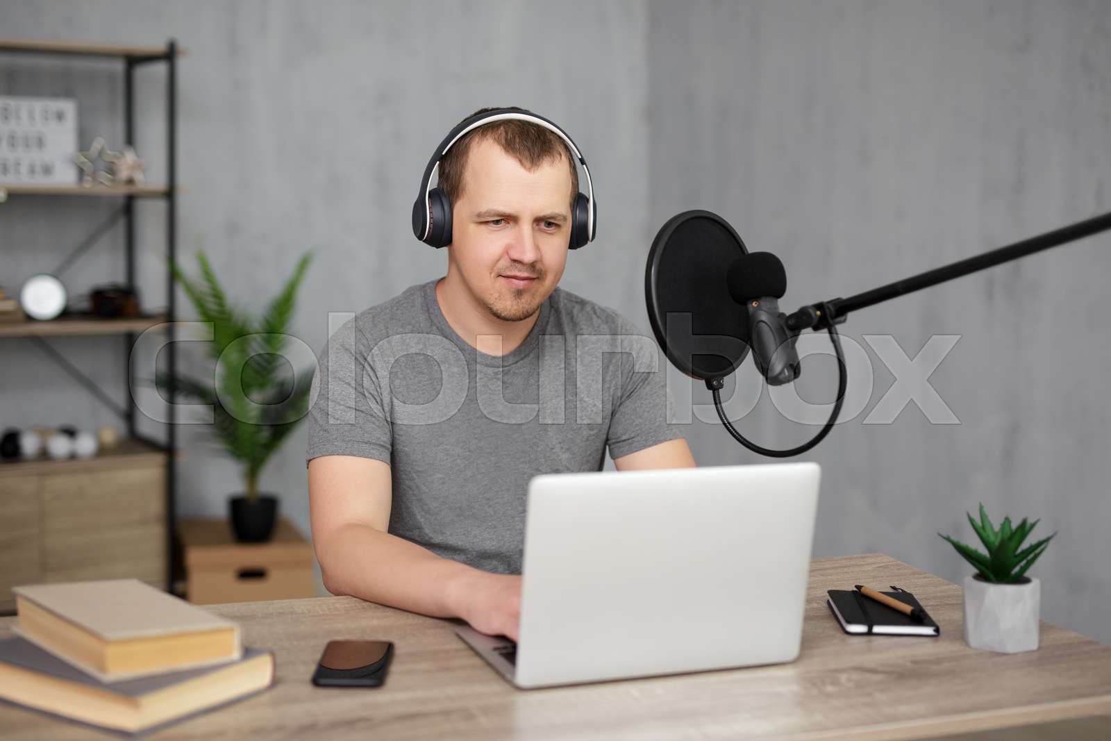 handsome man recording podcast at home | Stock image | Colourbox