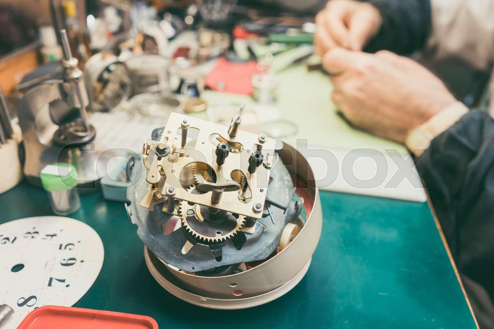Close up on clockwork of clock to be repaired in watchmaker workshop ...