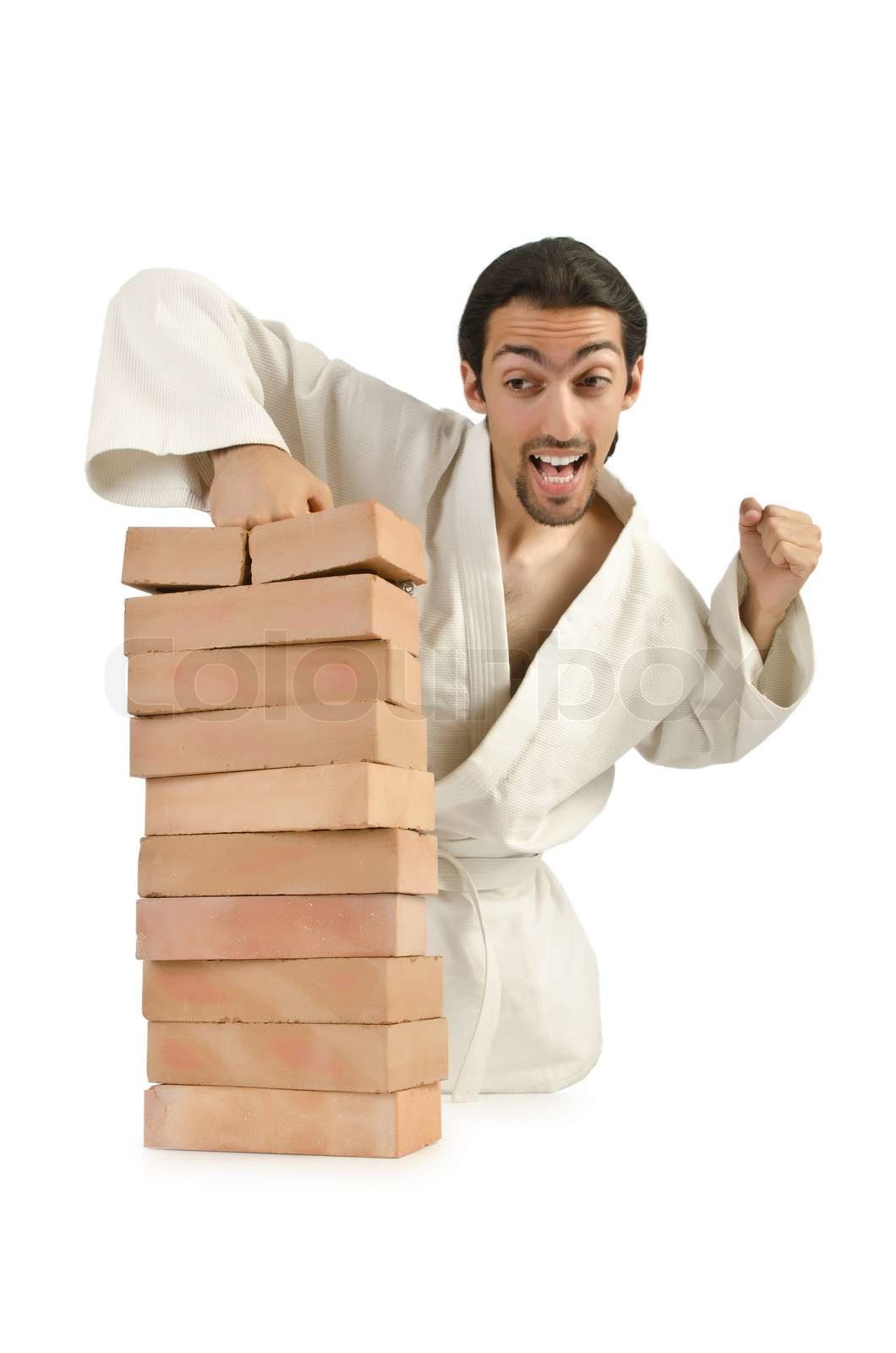 Karate man breaking bricks on white | Stock image | Colourbox