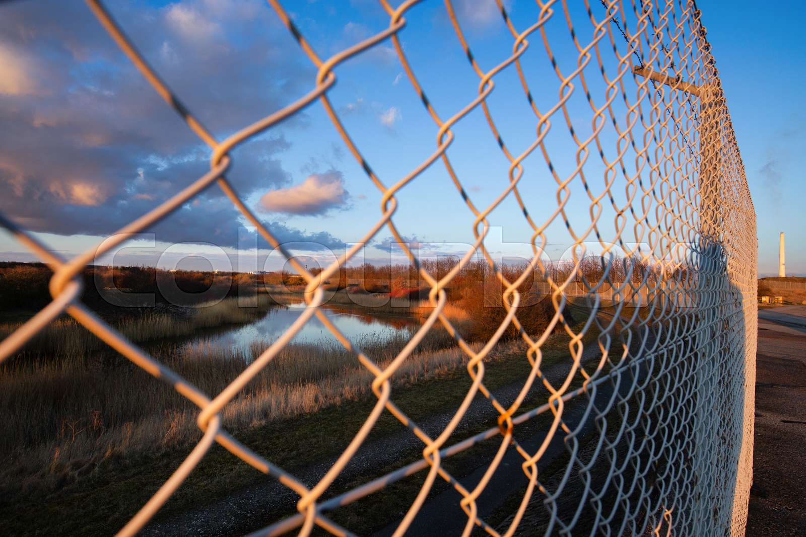 Lake area surrounded by fence | Stock image | Colourbox