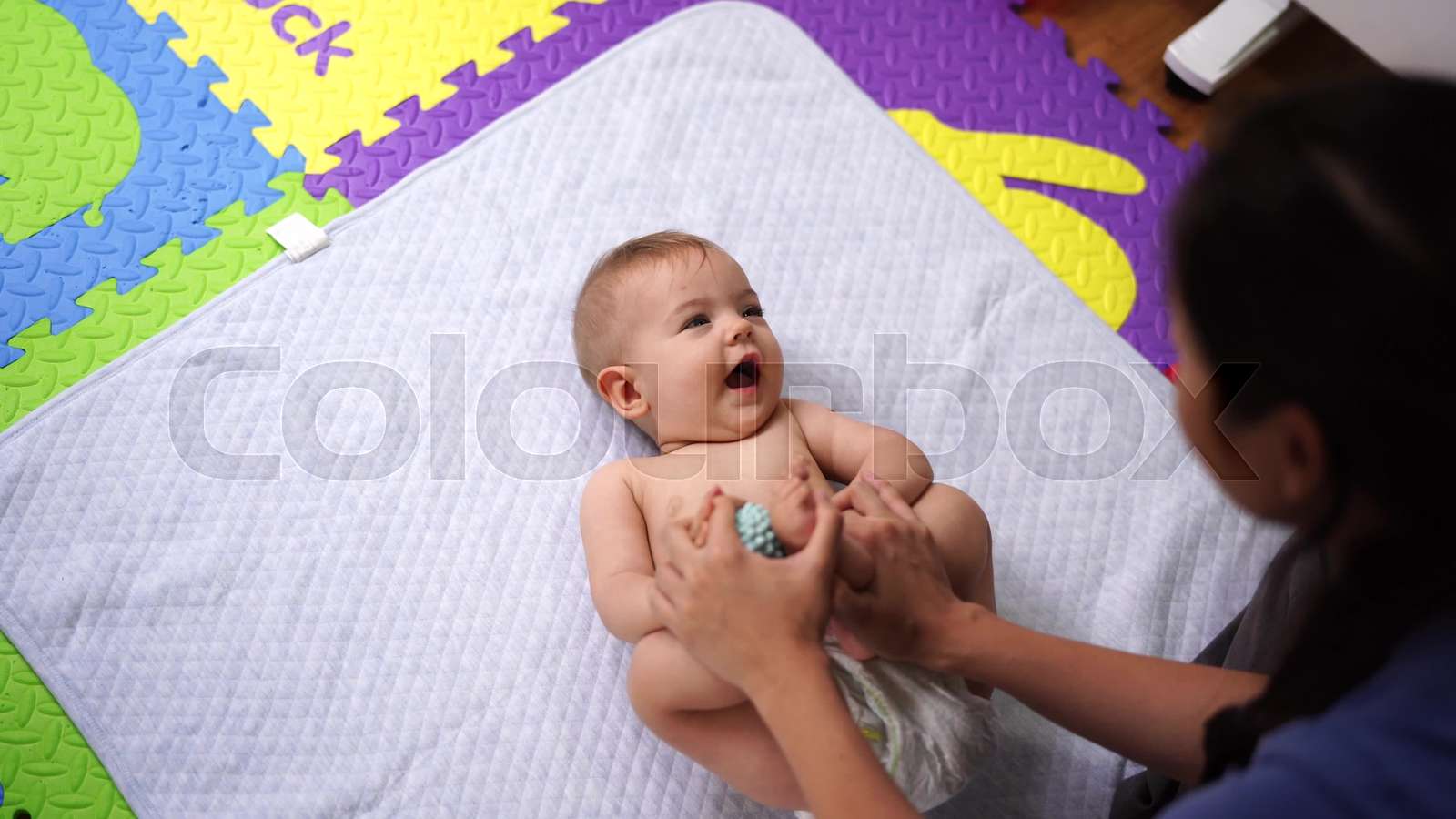 Mom turns the baby on the side and on the back | Stock video | Colourbox