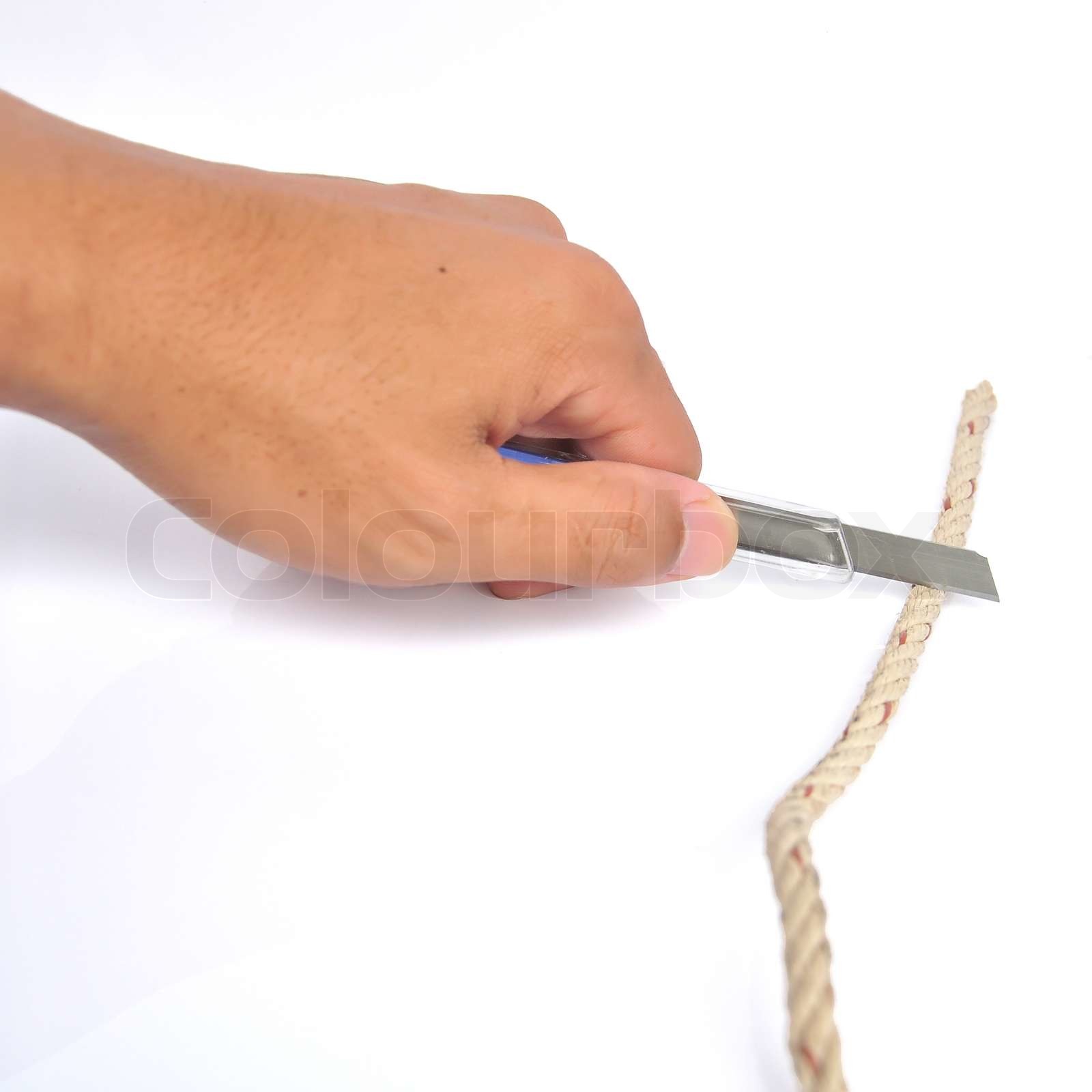 A hand holds a rope, utility knife cuts the same string | Stock image ...