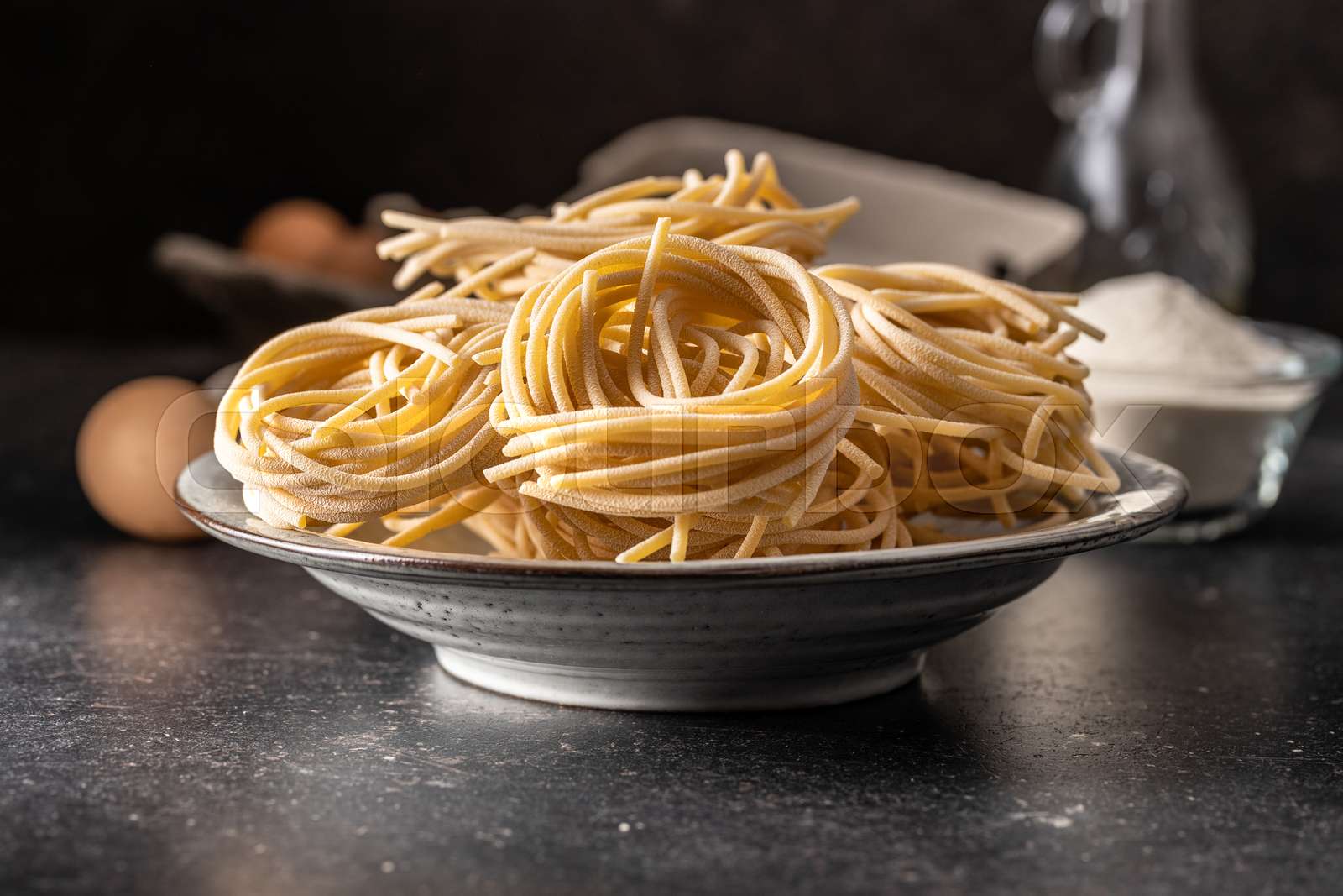 Italian pasta nest. Uncooked spaghetti nest in plate. | Stock image ...