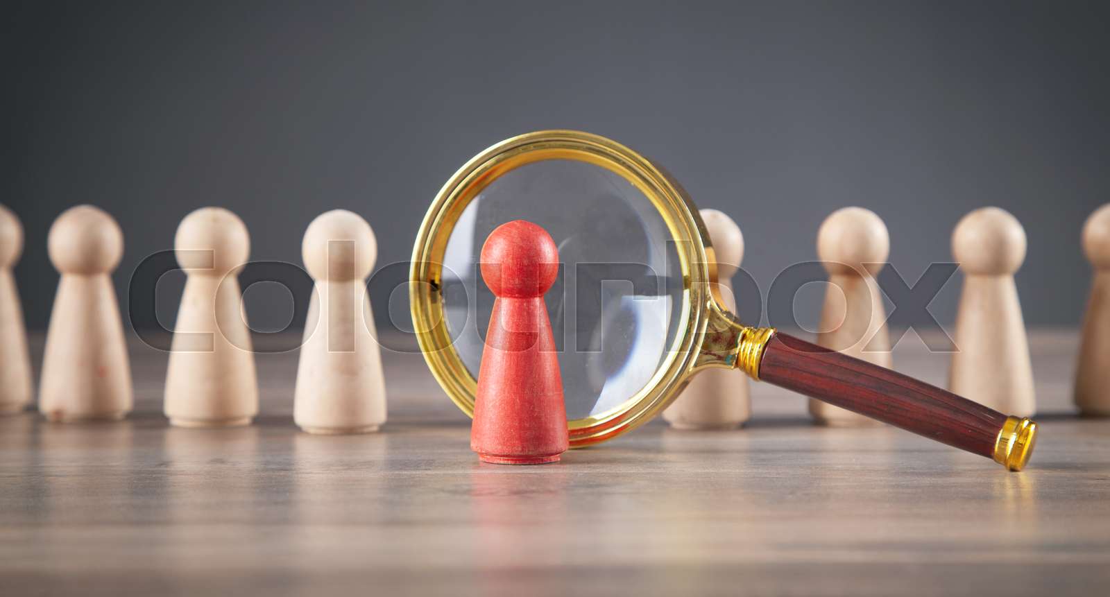 Magnifying glass and wooden human figures. | Stock image | Colourbox