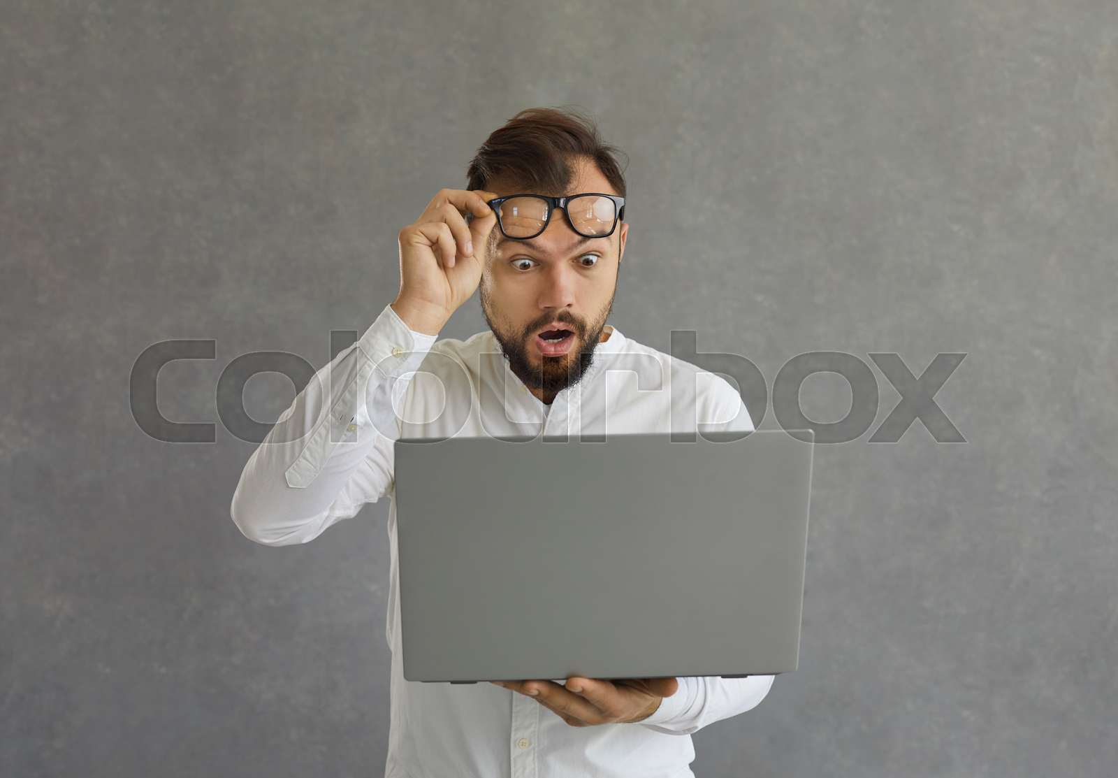 Man looking at screen of his laptop computer with expression of big ...