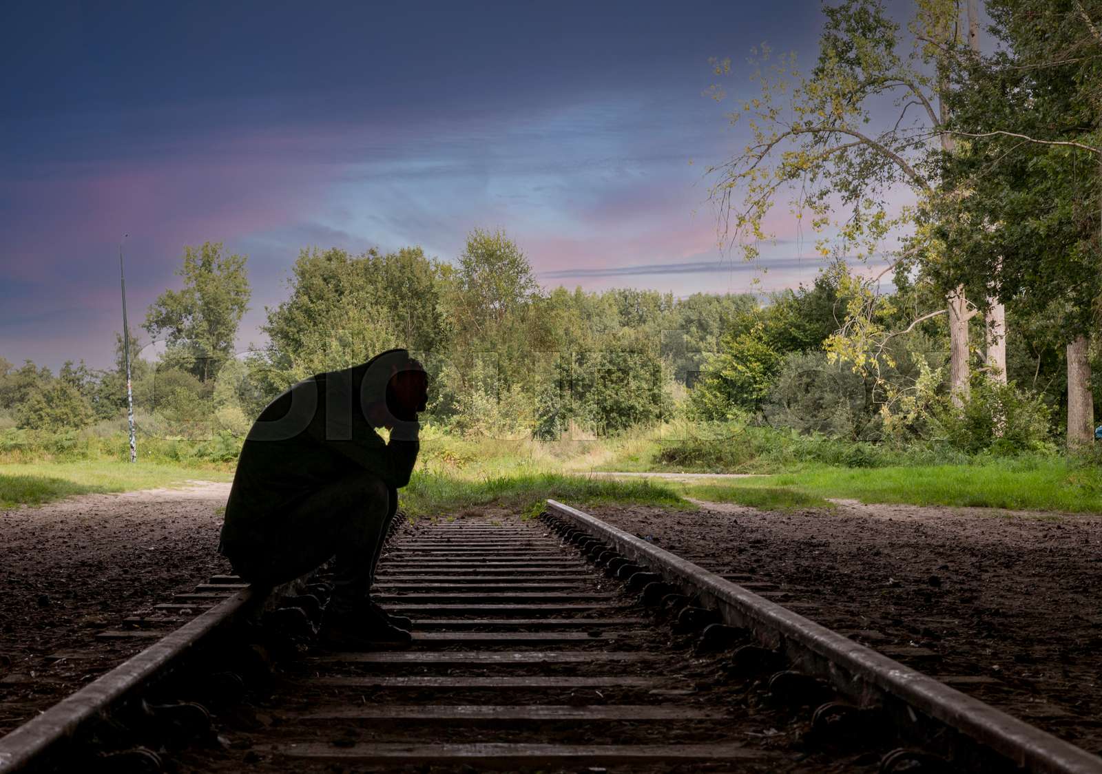 man sitting on a railway track | Stock image | Colourbox