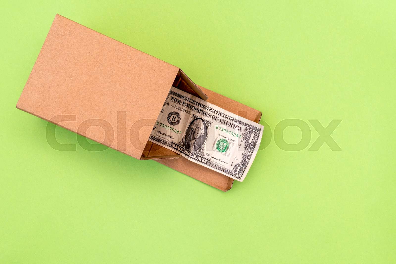 A dollar bulging out of a cardboard box | Stock image | Colourbox