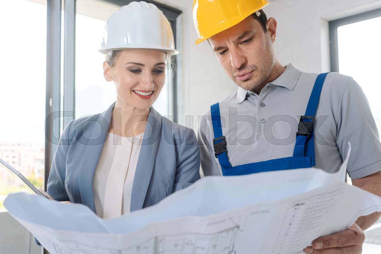 Construction worker and architect looking at plan on site | Stock image ...