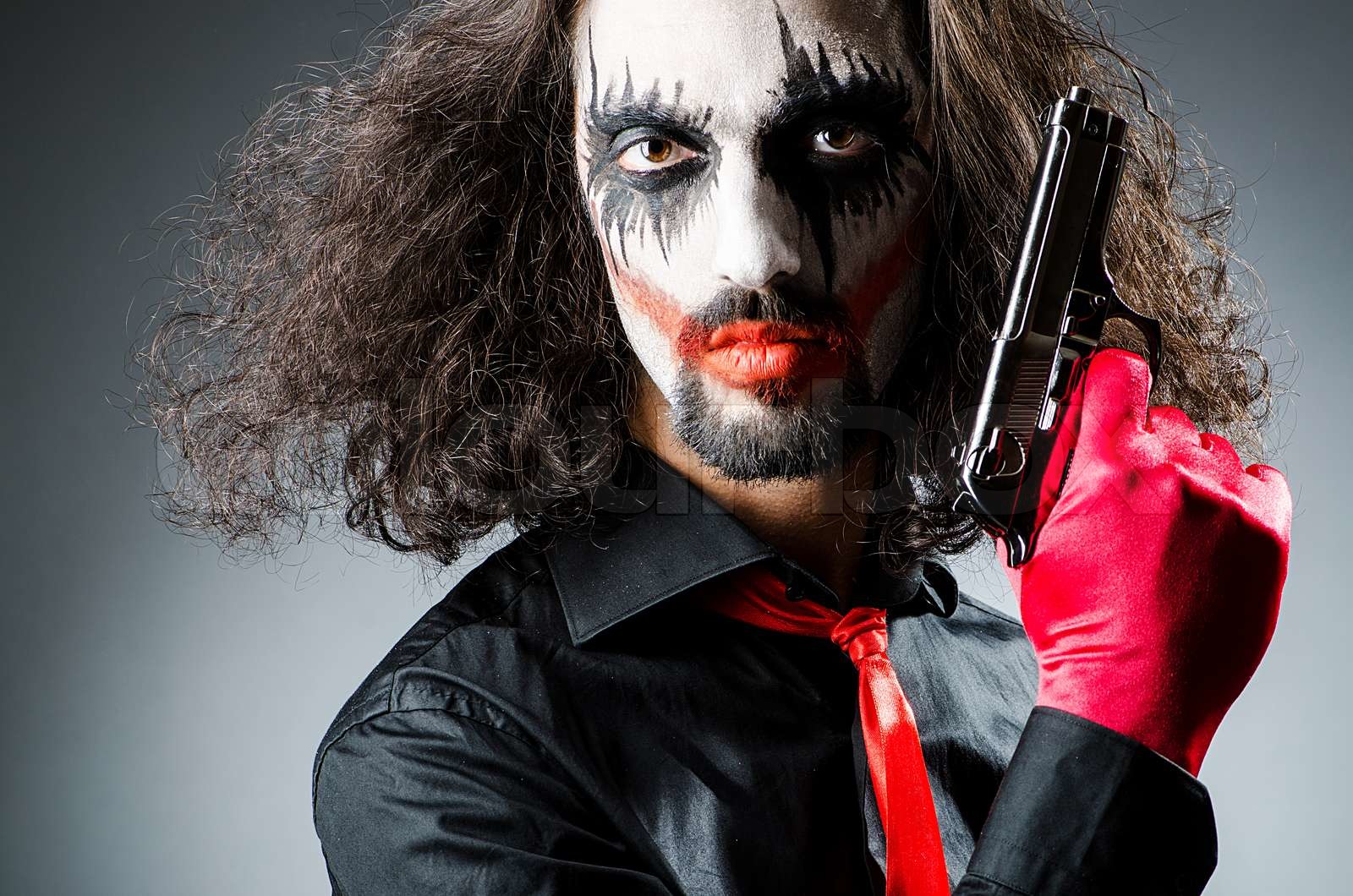 Evil clown with gun in dark room | Stock image | Colourbox