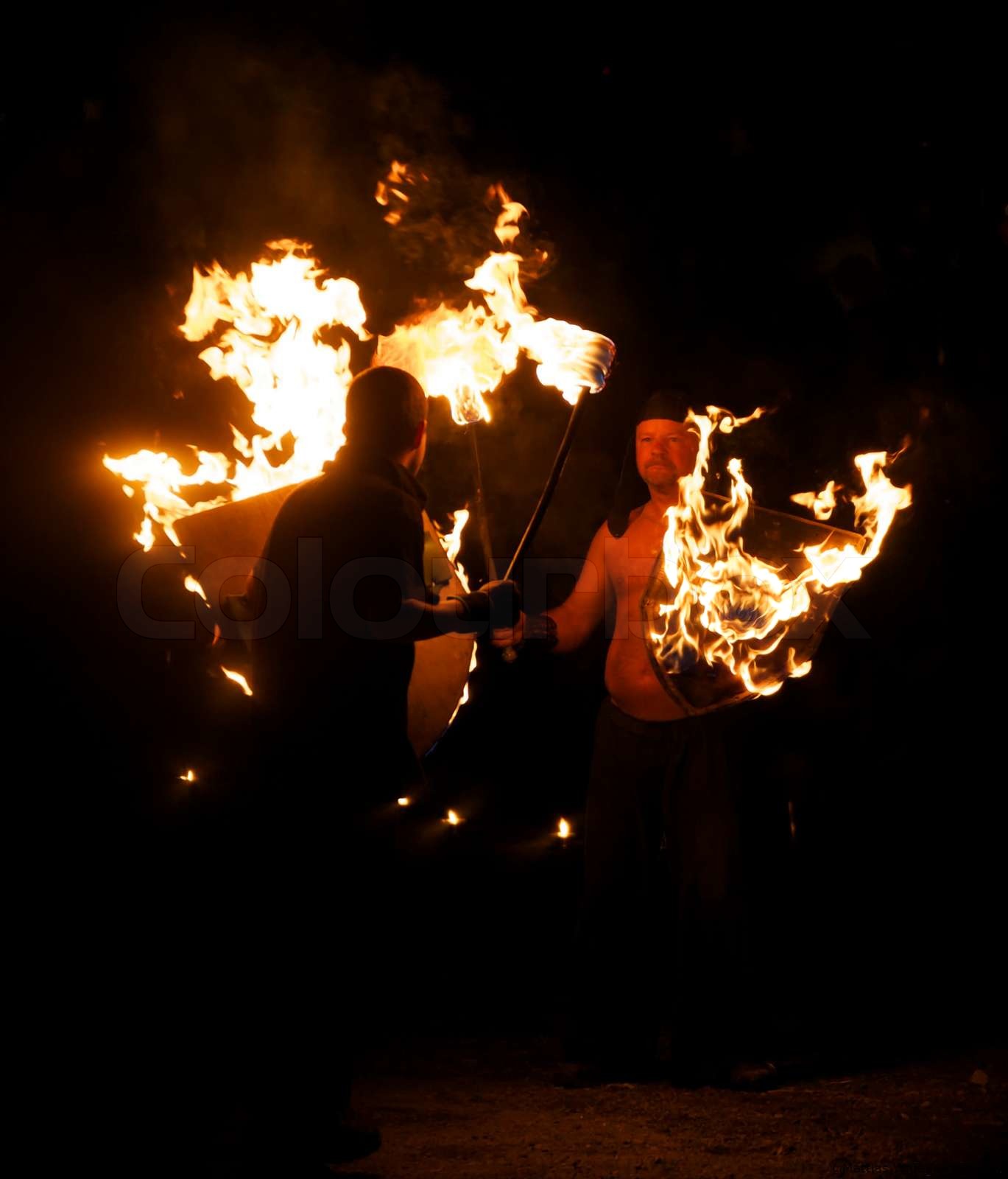 A medieval fire-fight at night. Contestants joustling. | Stock image ...