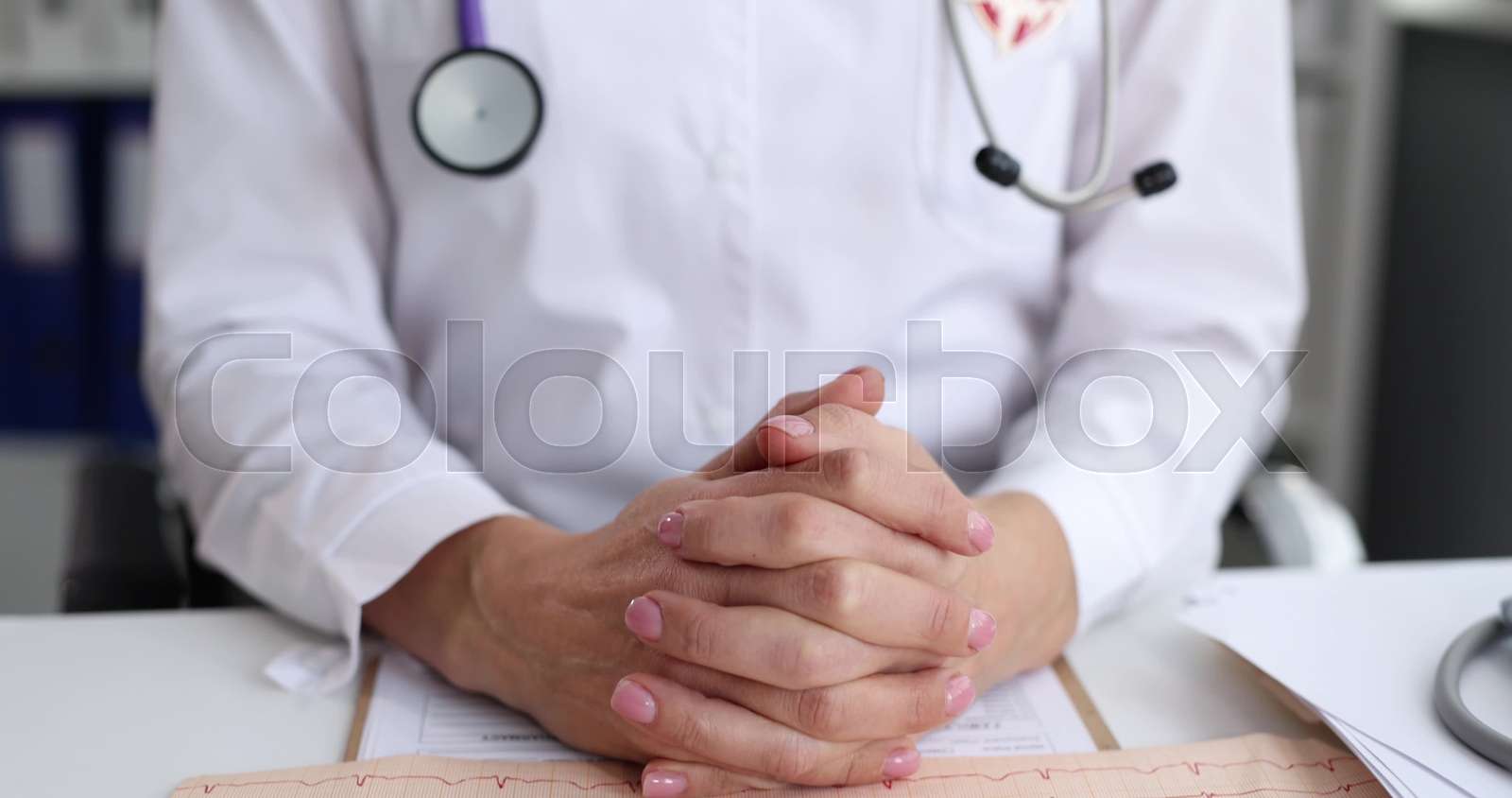 Doctor cardiologist with ecg icon sitting at table in clinic 4k movie ...