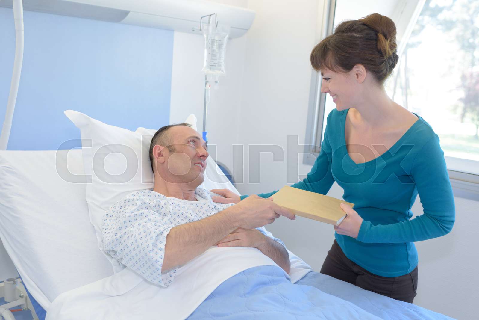 caring for a sick loved one in hospital bed | Stock image | Colourbox