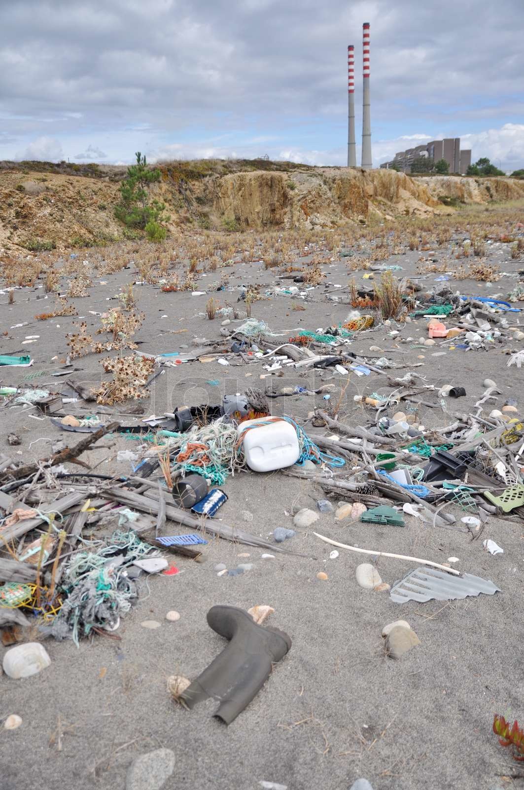 Trash on the seashore next to a factory | Stock image | Colourbox