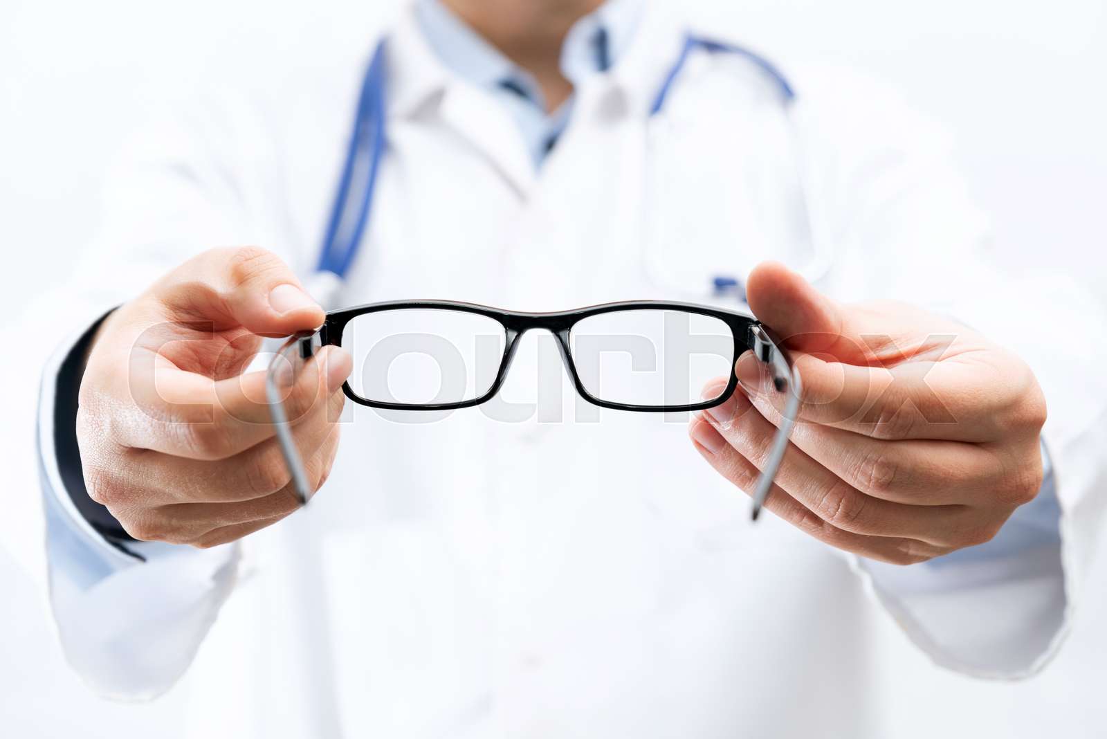 Optometrist holds glasses to try on | Stock image | Colourbox