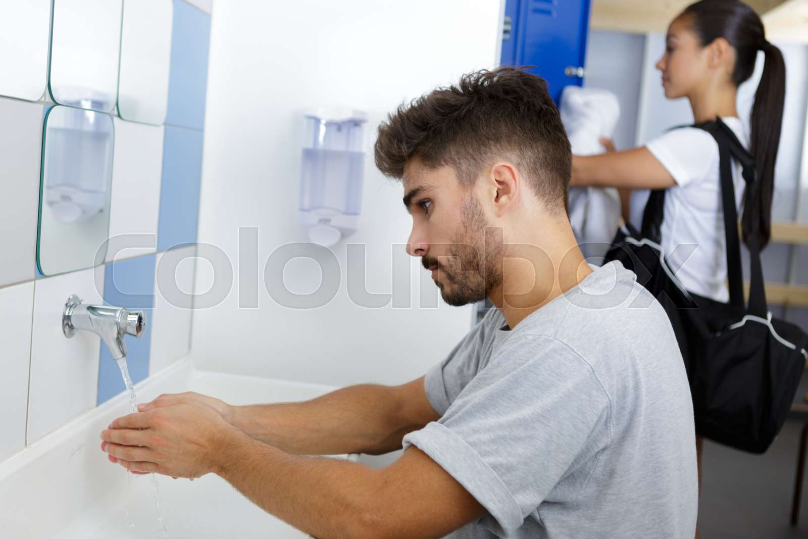 man washing his hands in the gym washroom | Stock image | Colourbox