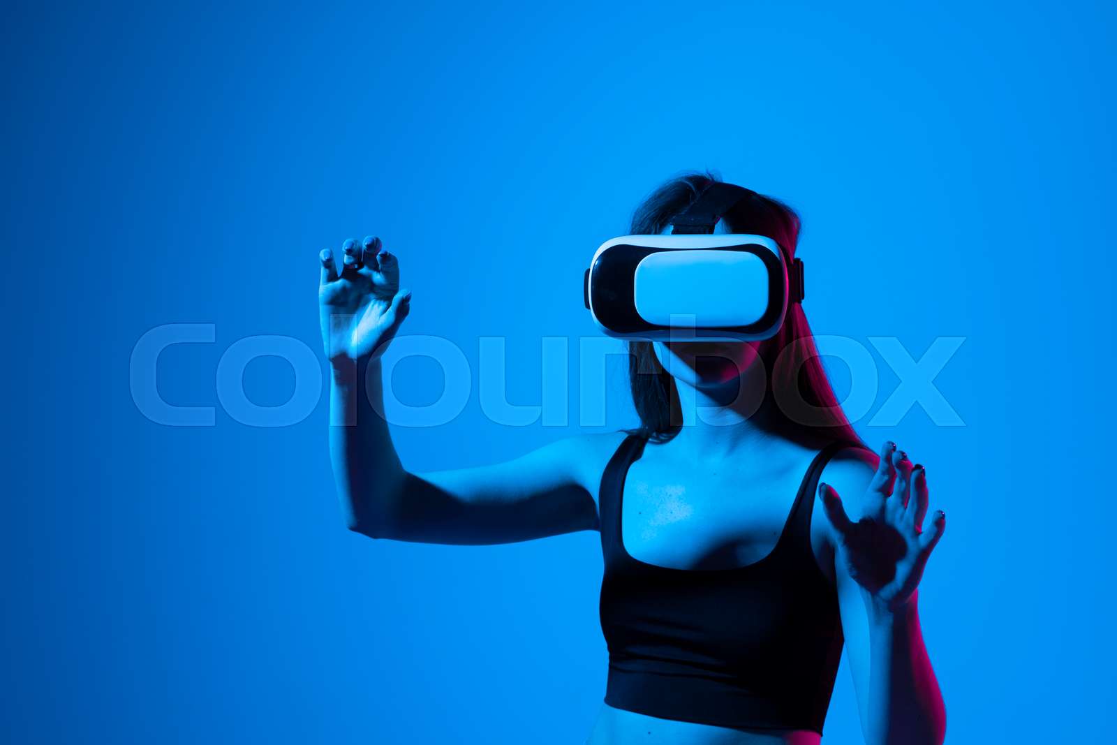 Close up of young woman stands in studio wearing VR glasses and swiping ...