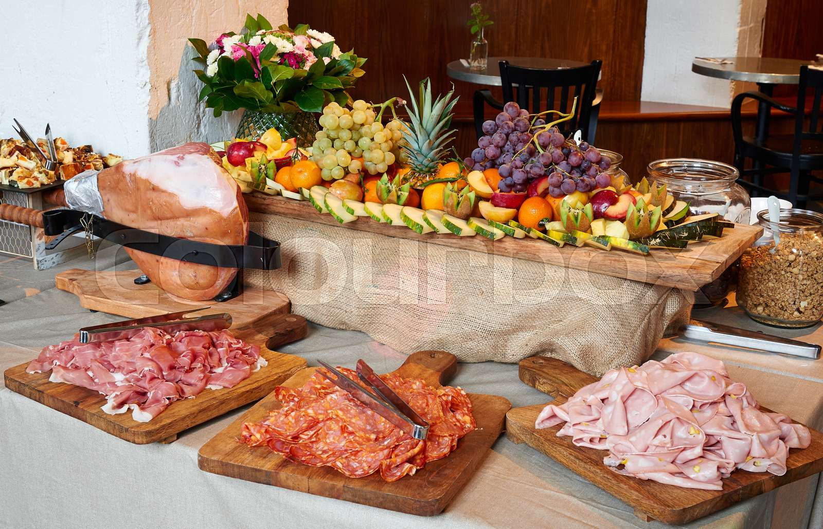 Colored buffet with seasonal fresh fruits and different kind of Ham ...