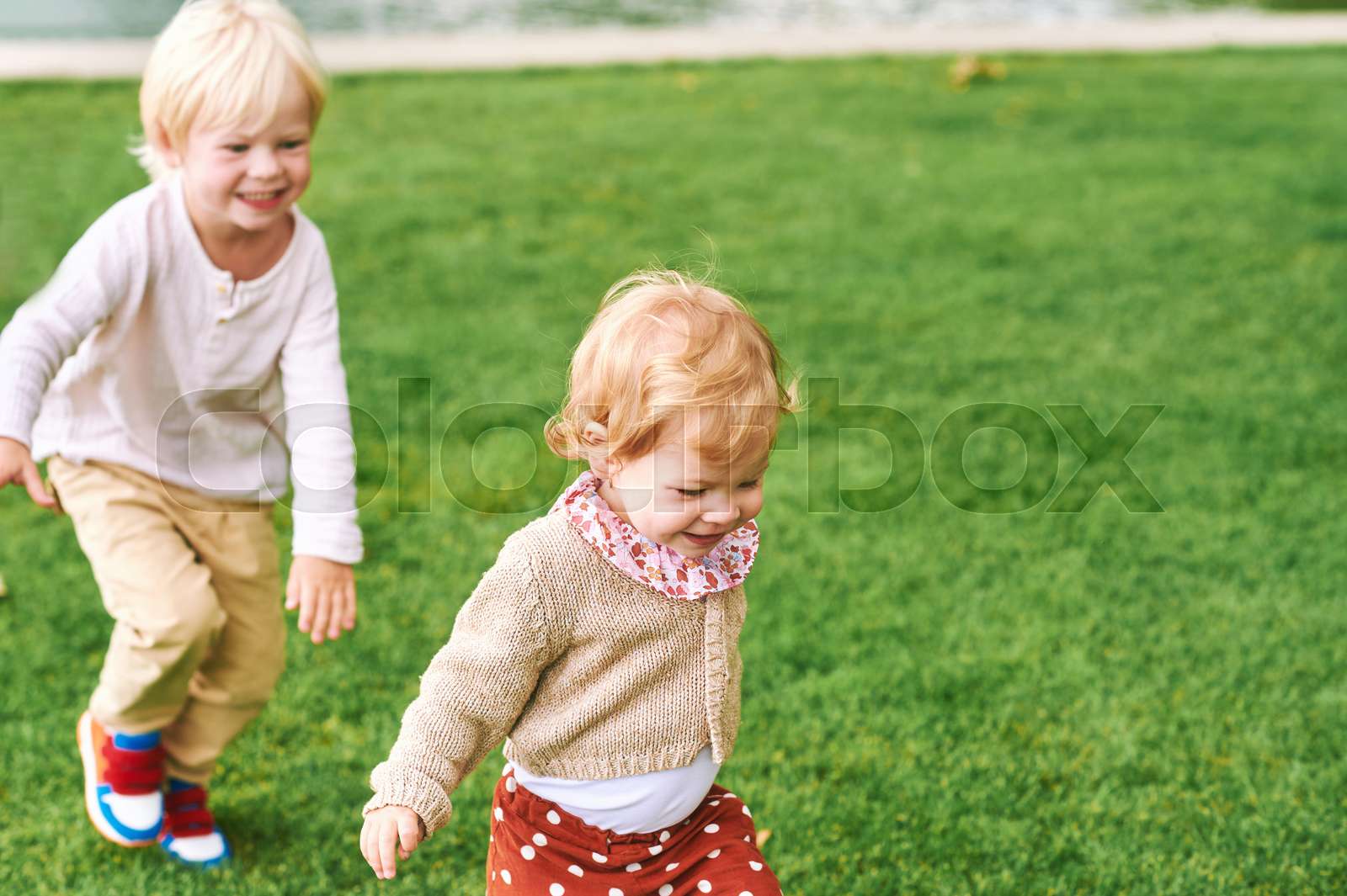Outdoor portrait of adorable happy children playing together, running ...